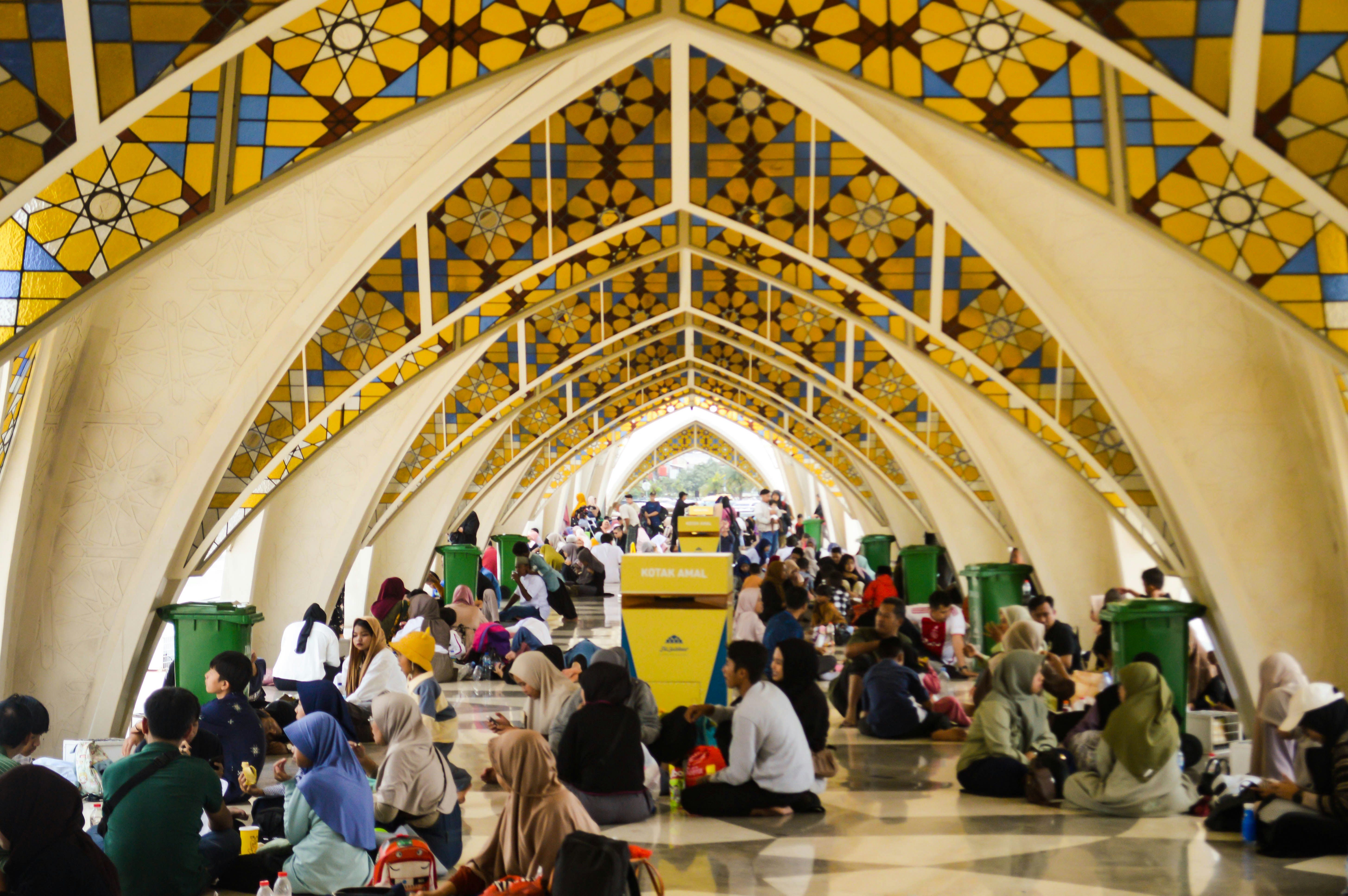 Under the Mosaic Vault: A Crowd Traverses a Sunlit Archway Corridor