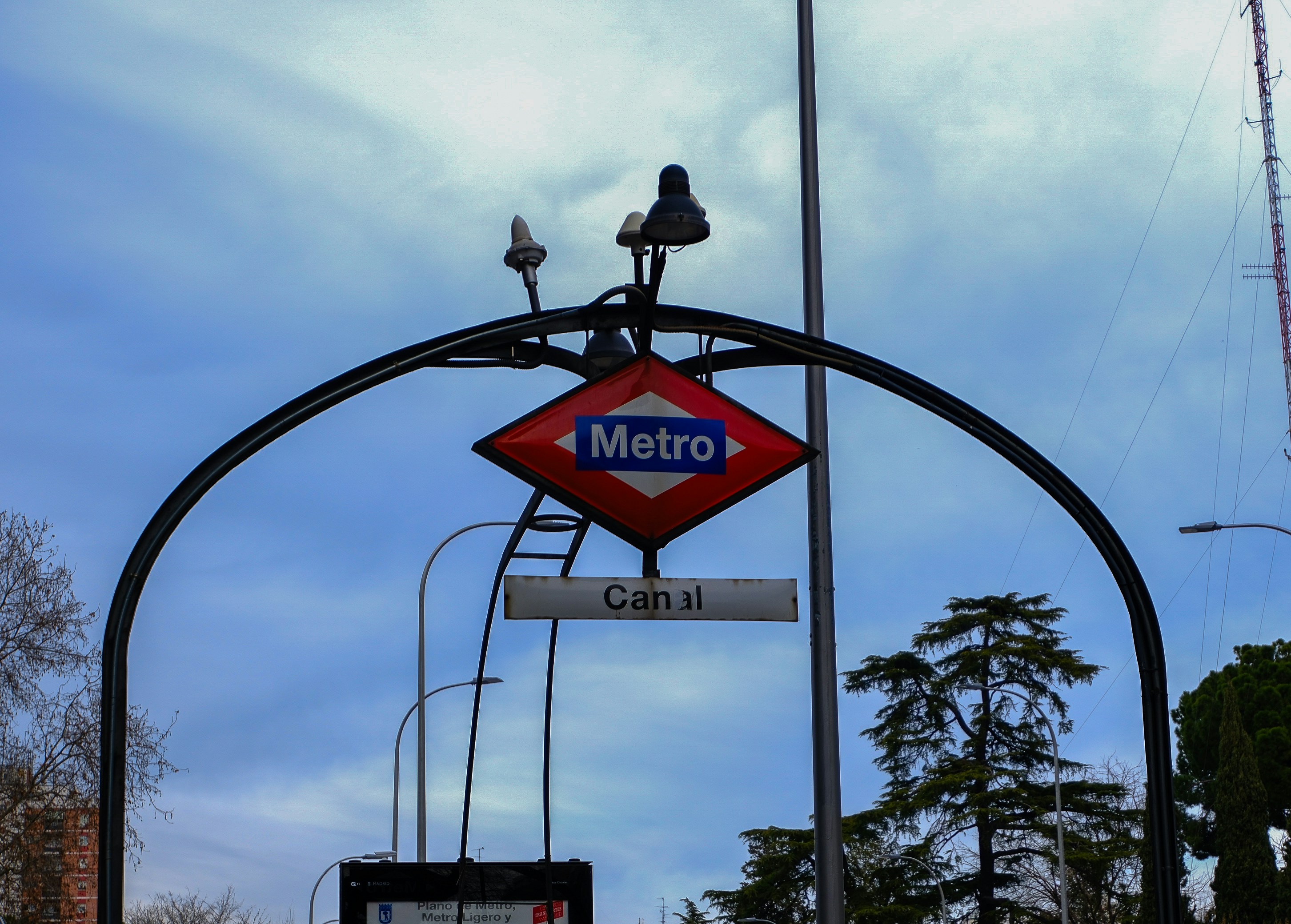 Red Metro Diamond Under a Curved Arch Against a Clear Blue Sky