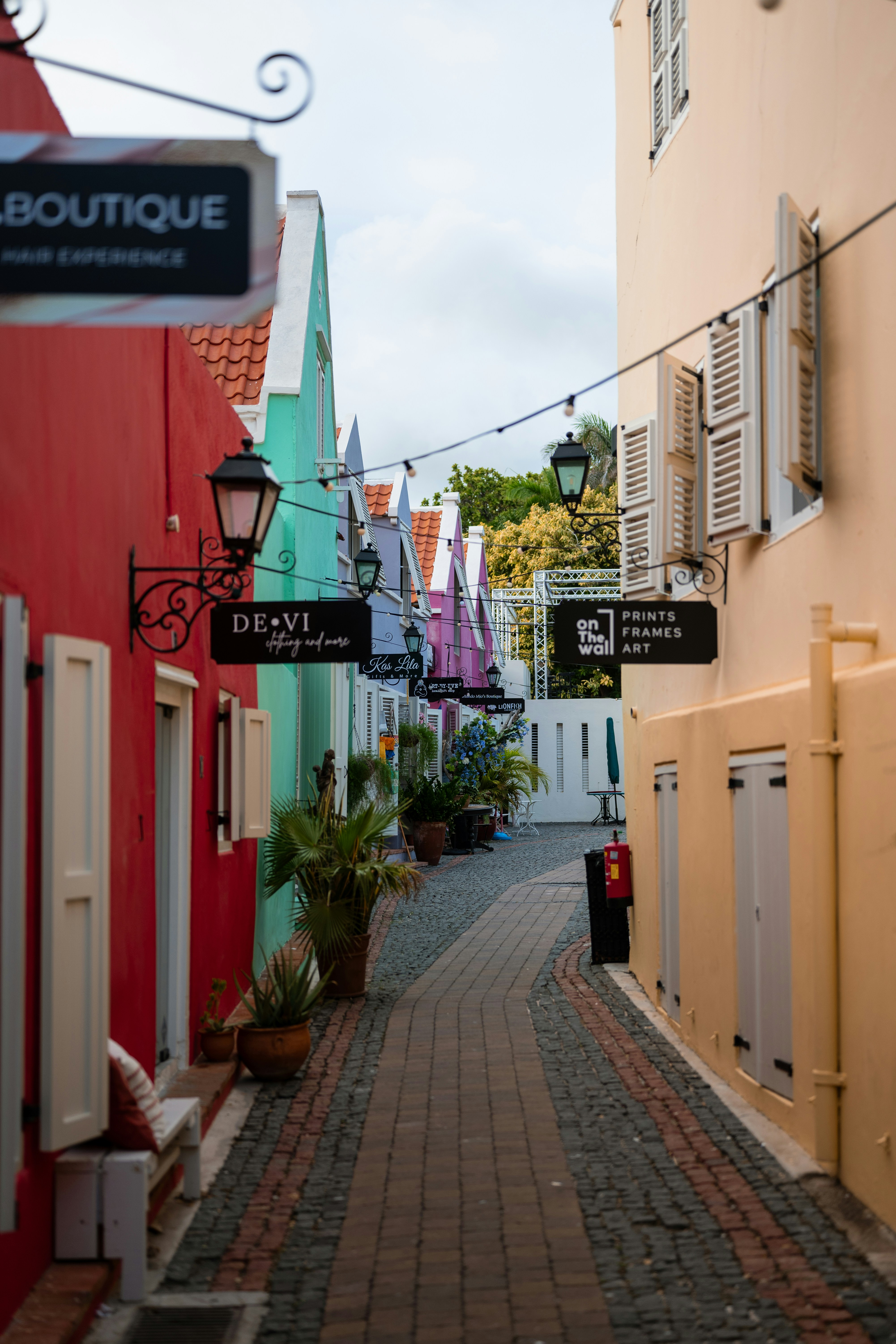 Pastel Lane: A Cobbled Alley Framed by Colorful Facades and Hanging Signs