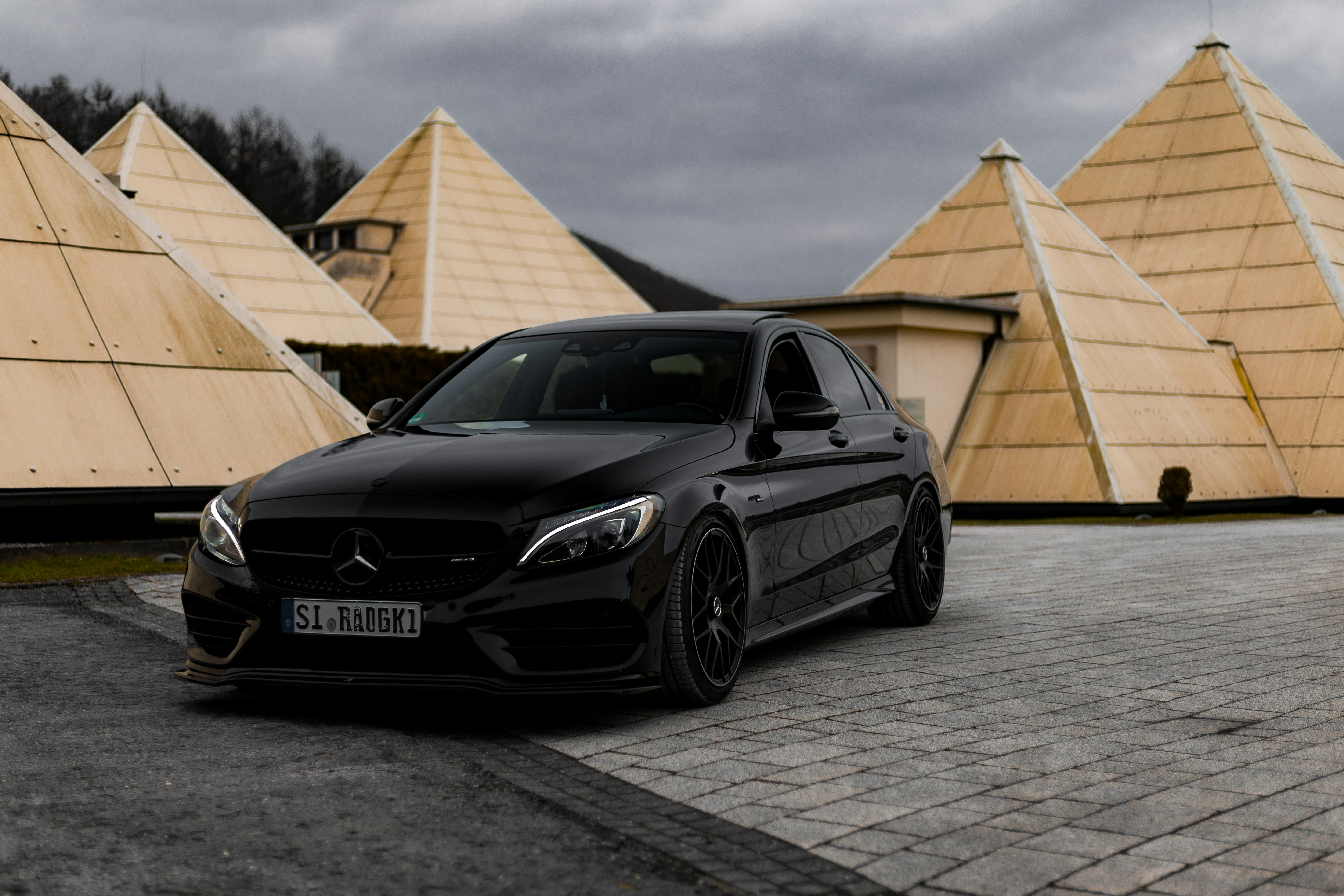 A black car parked in front of a group of pyramids photo – Free ...