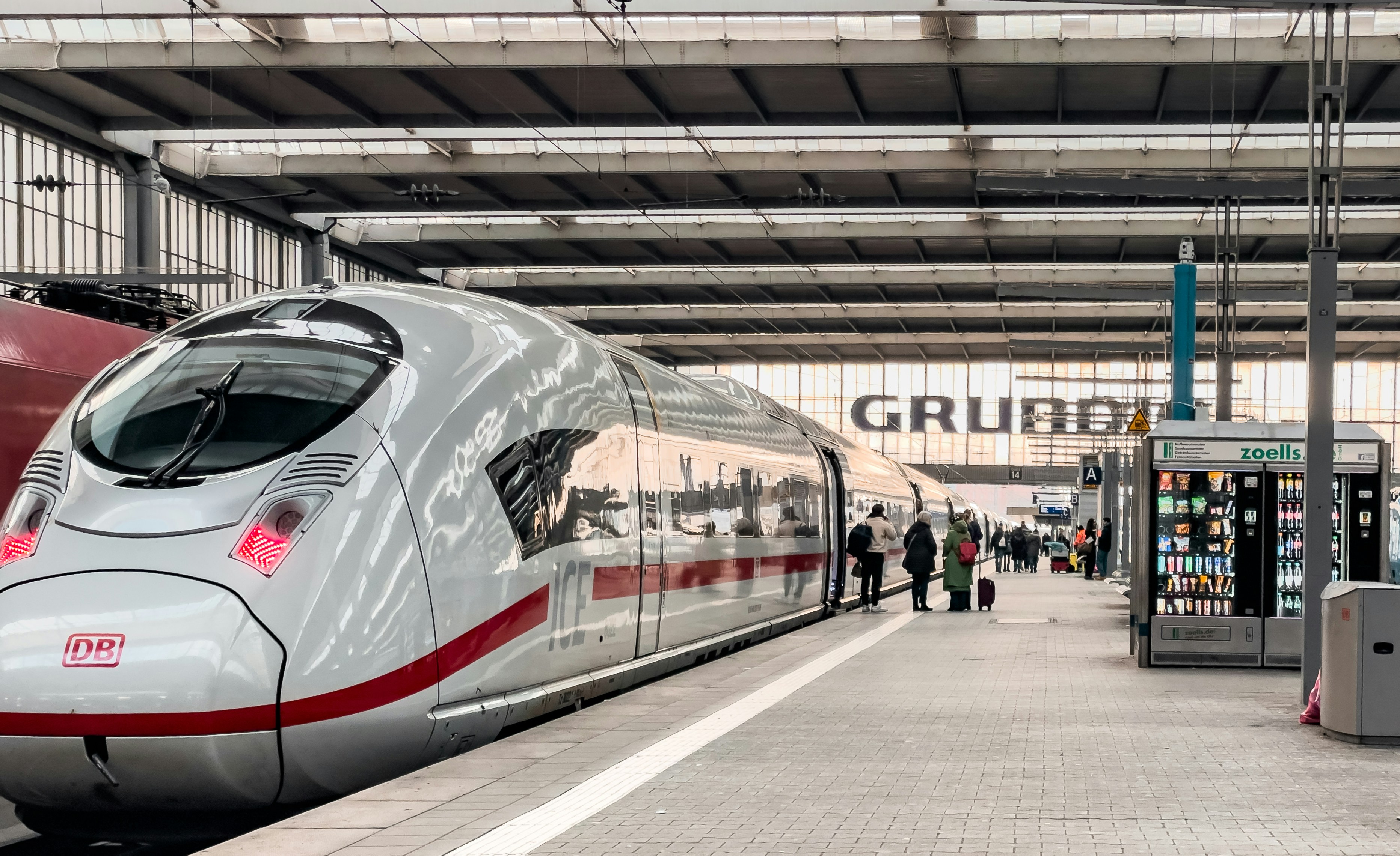 A silver train pulling into a train station photo – Free Car Image on Unsplash