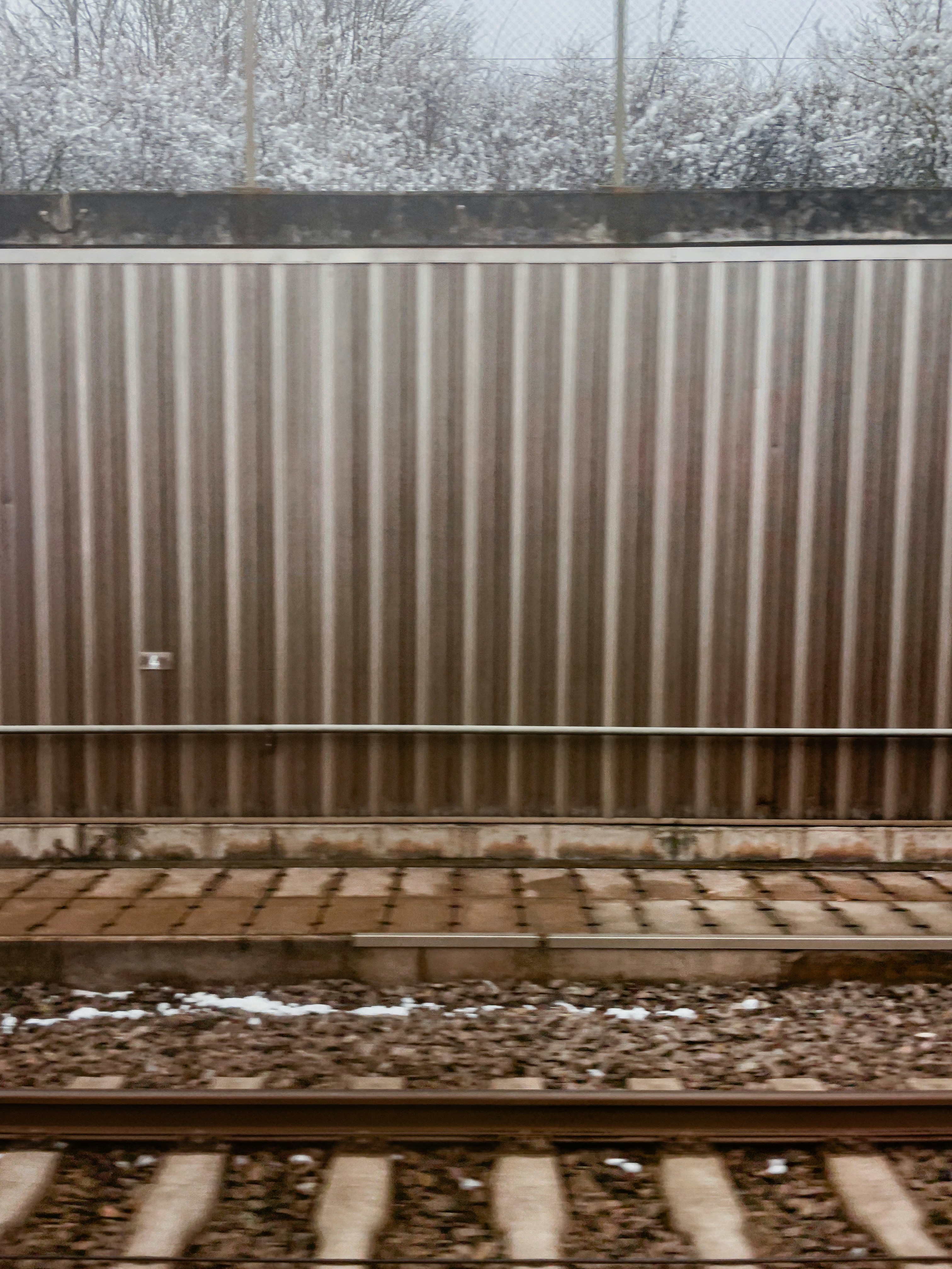 Winter Rail Silence: Corrugated Steel and Faint Snow