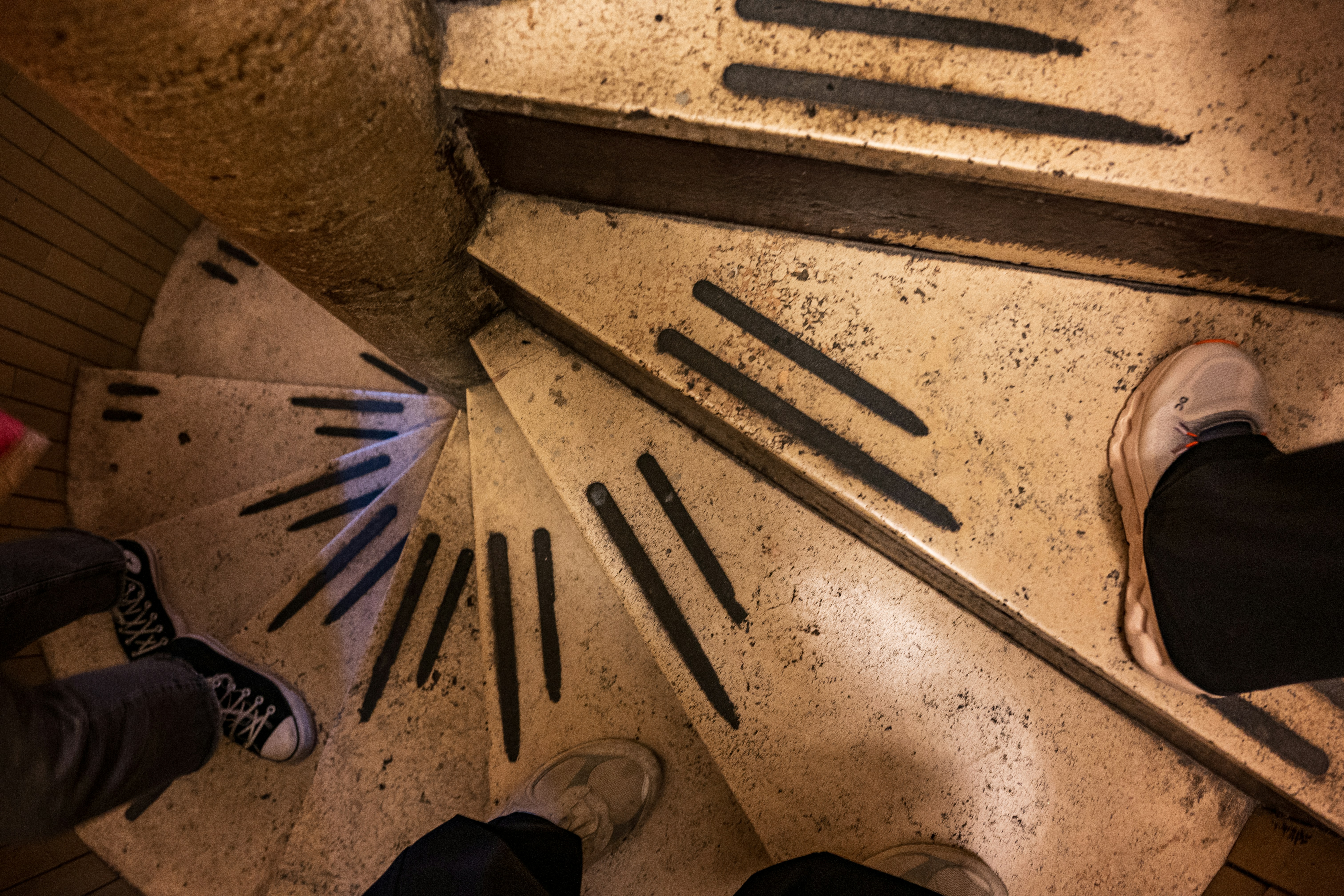 Convergence at the Spiral Core: Footwear Framing a Dusty Staircase