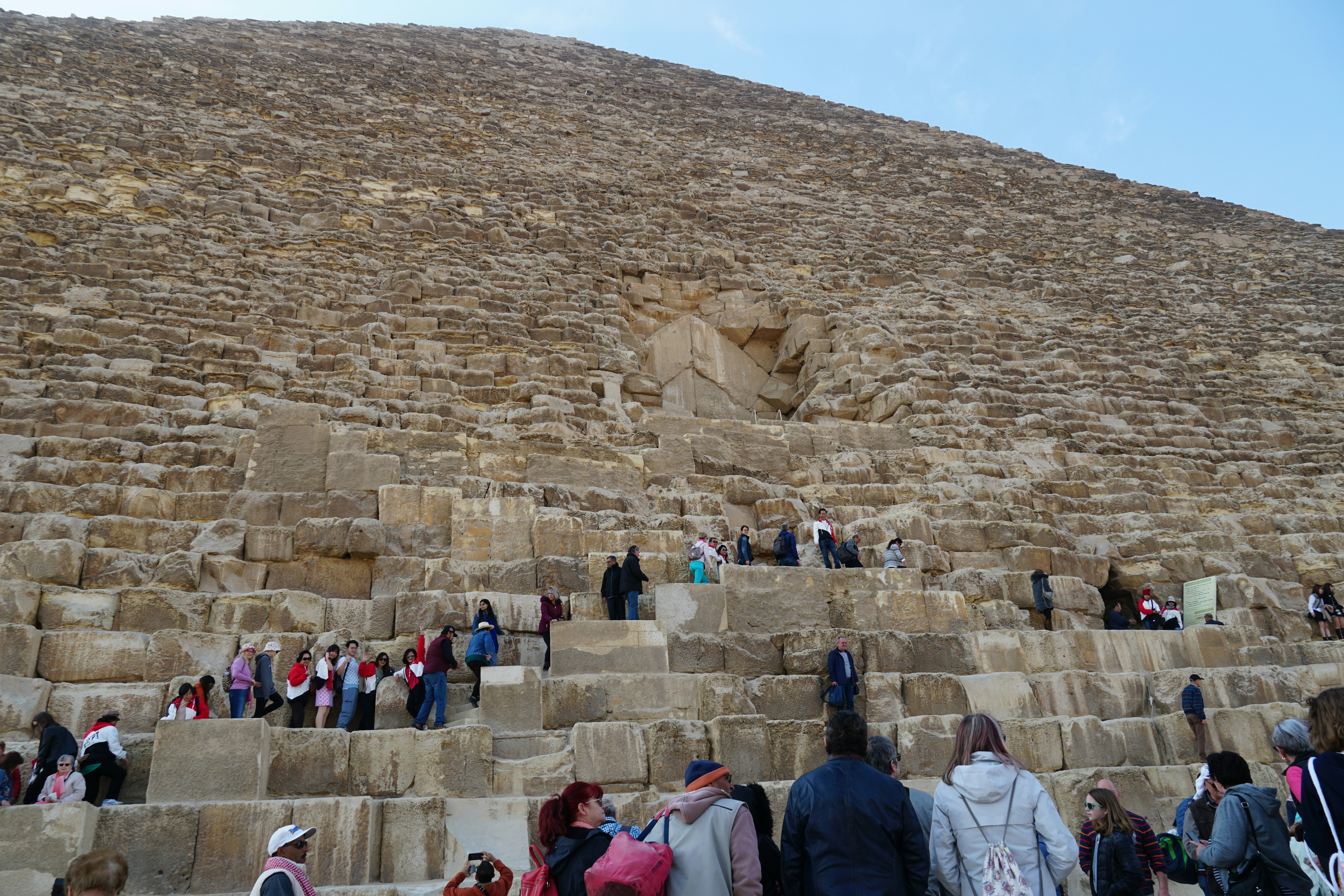 A group of people standing in front of a large pyramid photo – Free ...