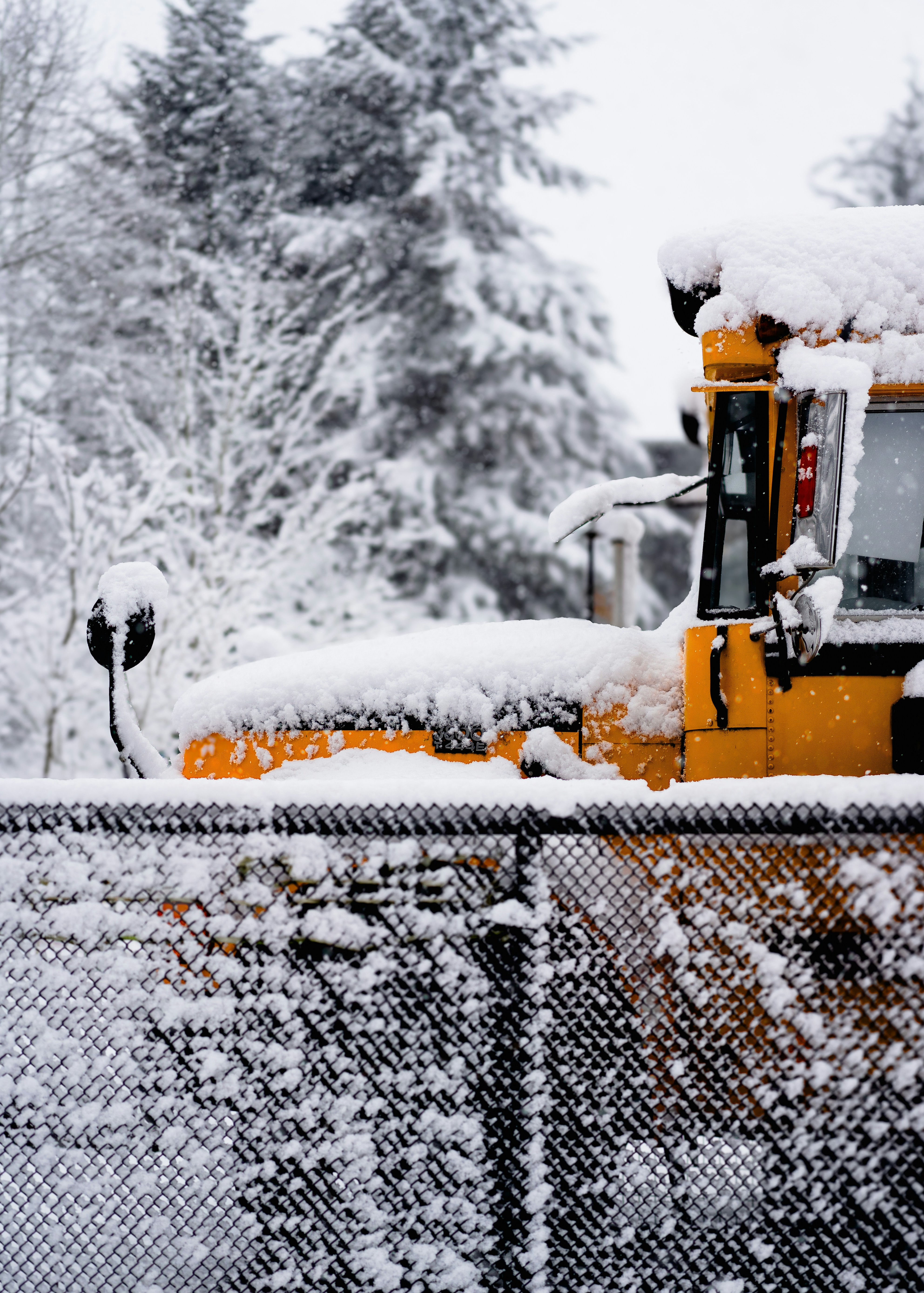 A snow plow is parked behind a fence photo – Free Vancouver Image on ...