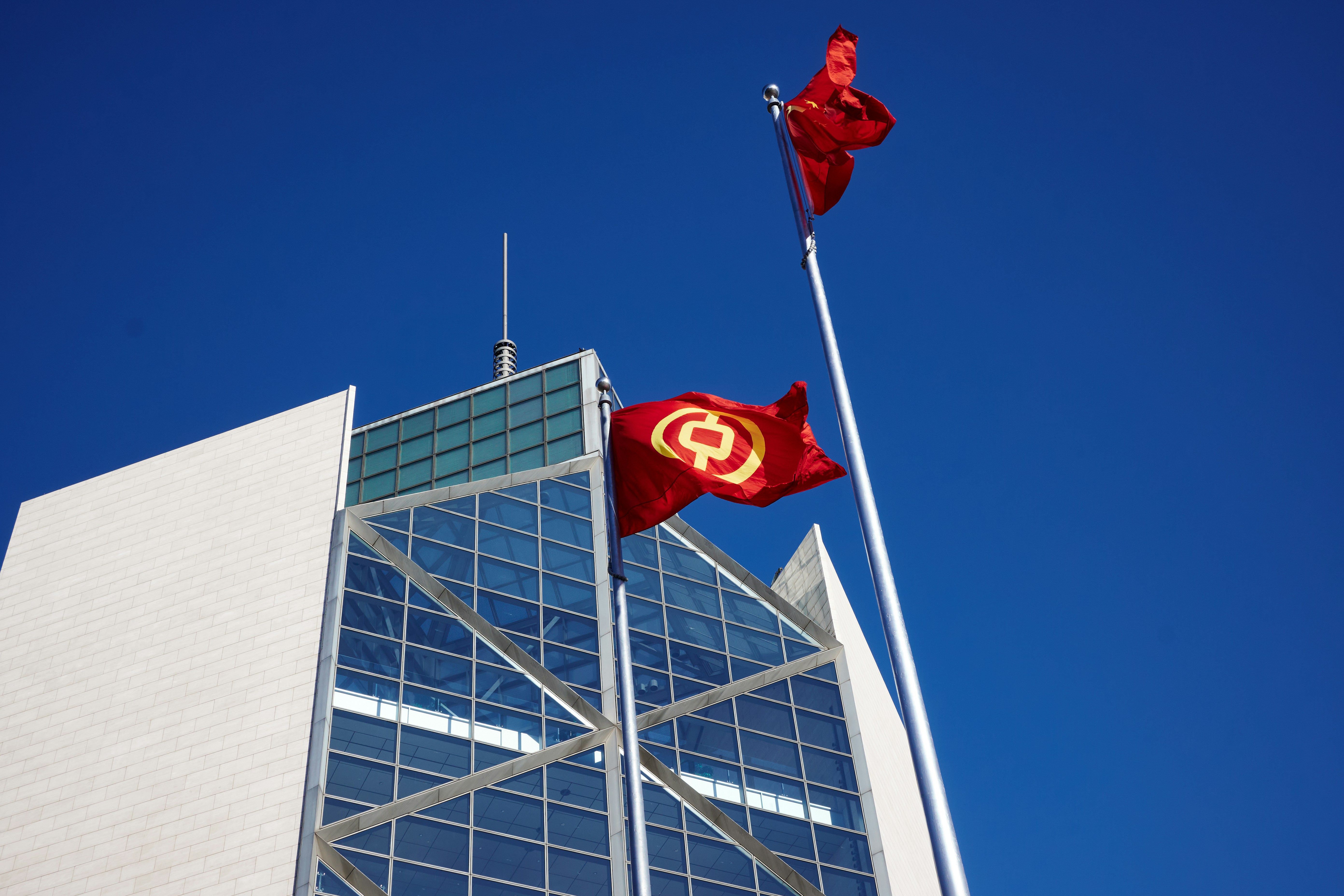 A building with two flags flying in front of it photo – Free China ...