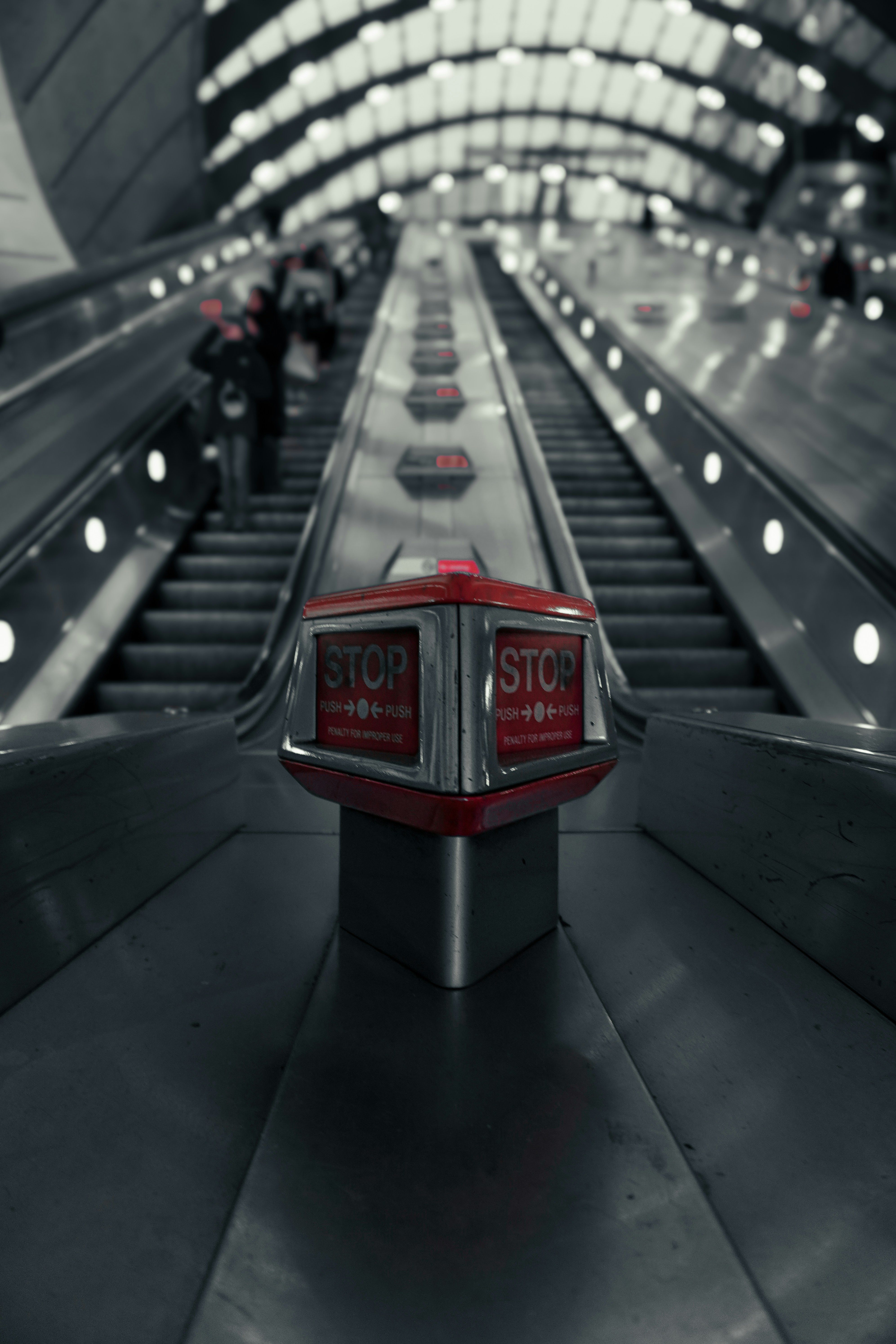 Red Sentinel on the Descent: A Monochrome Metro Escalator