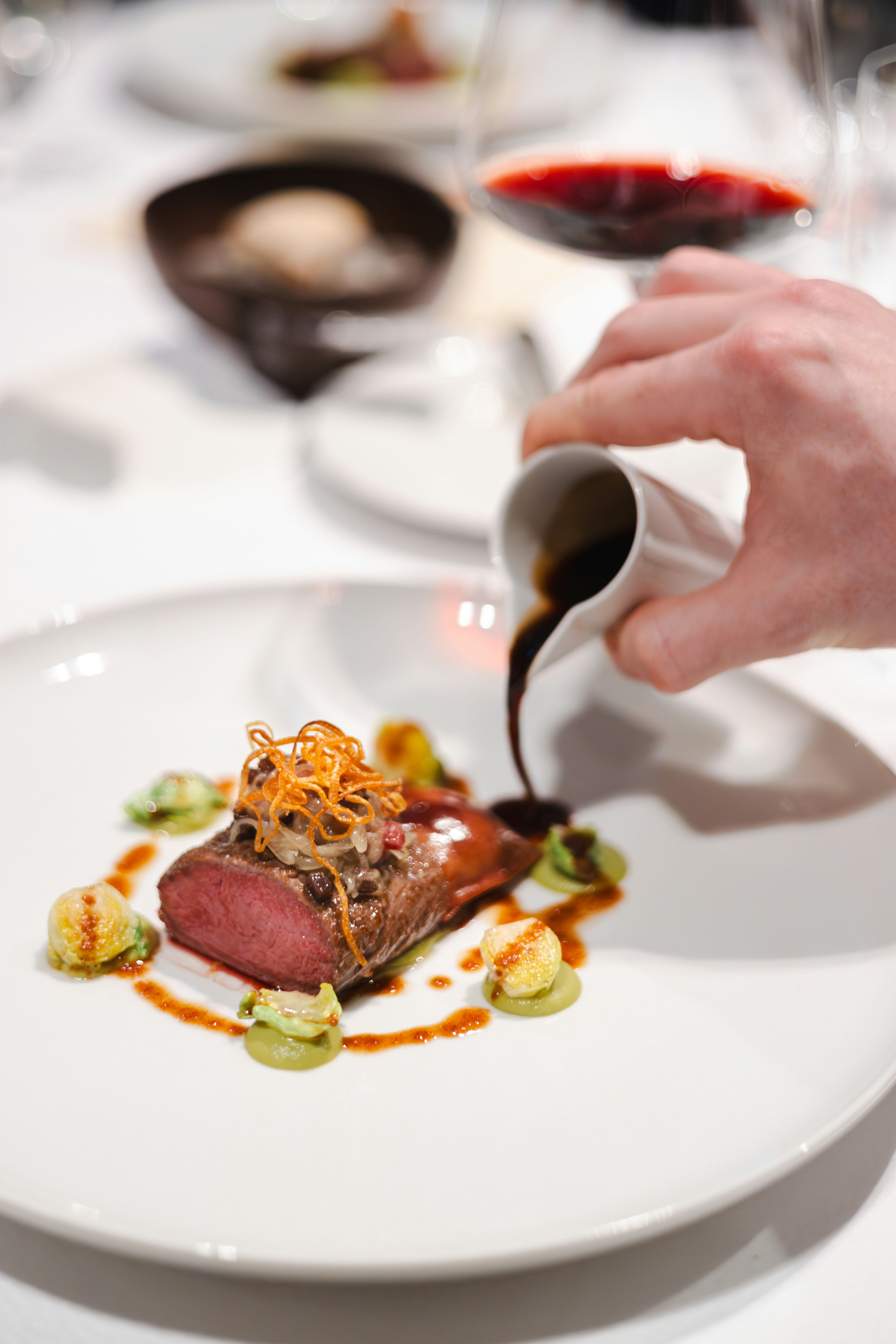 A person is pouring sauce on a plate of food photo – Free Food Image on ...