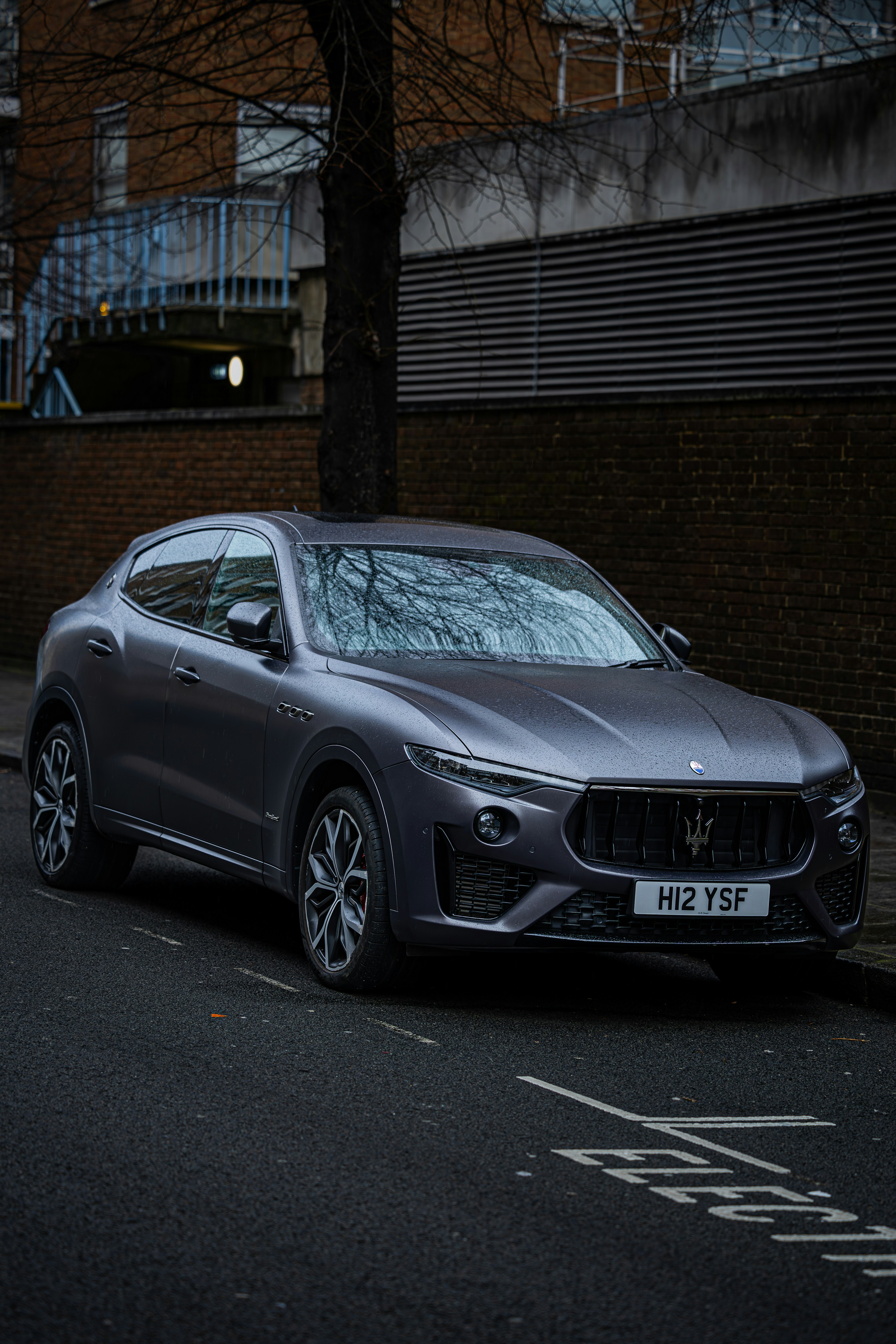 Midnight Maserati Levante Resting on Damp Urban Asphalt