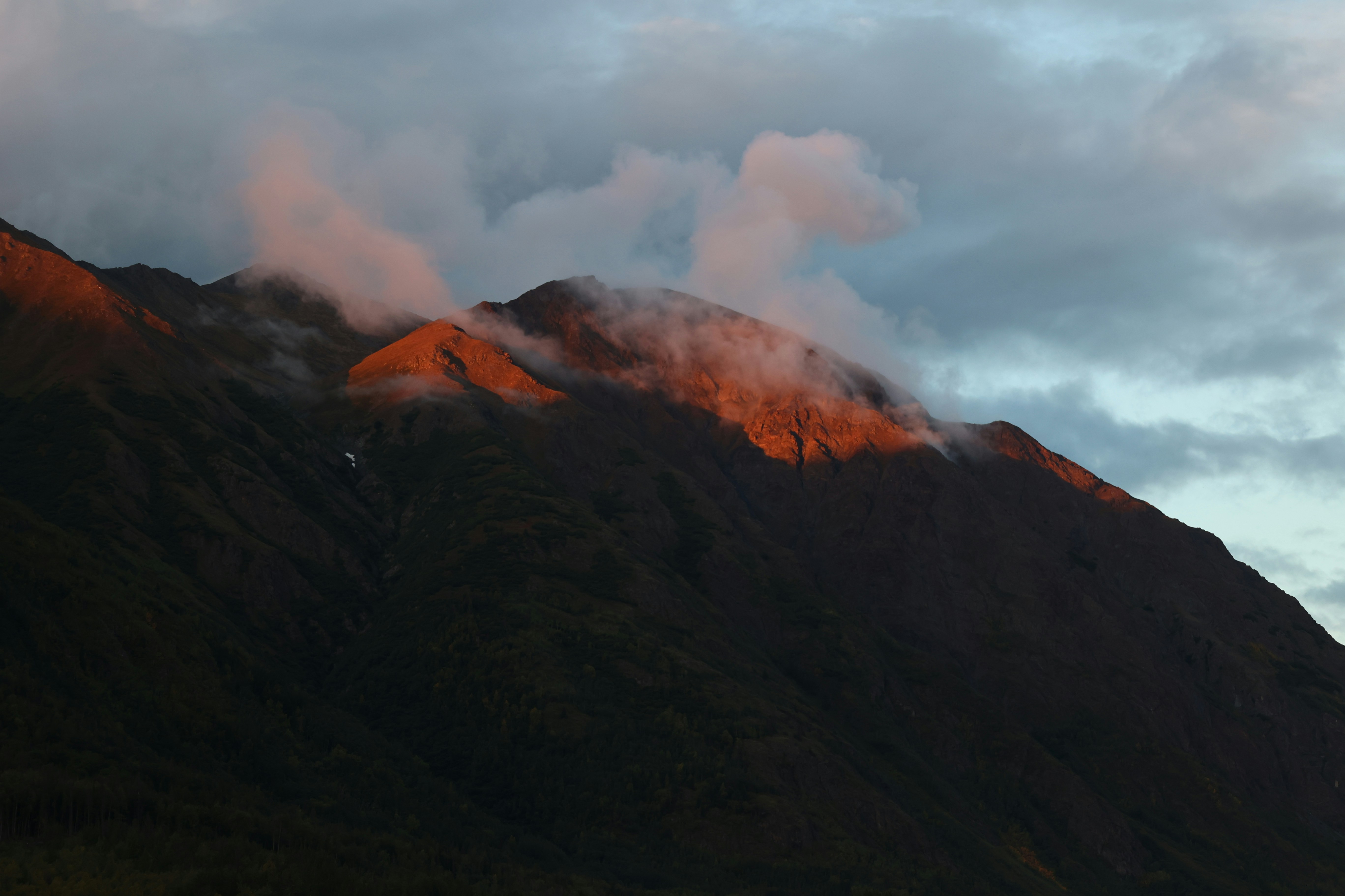 Peaks in Golden Light: Clouds Cloak a Mountain Crest