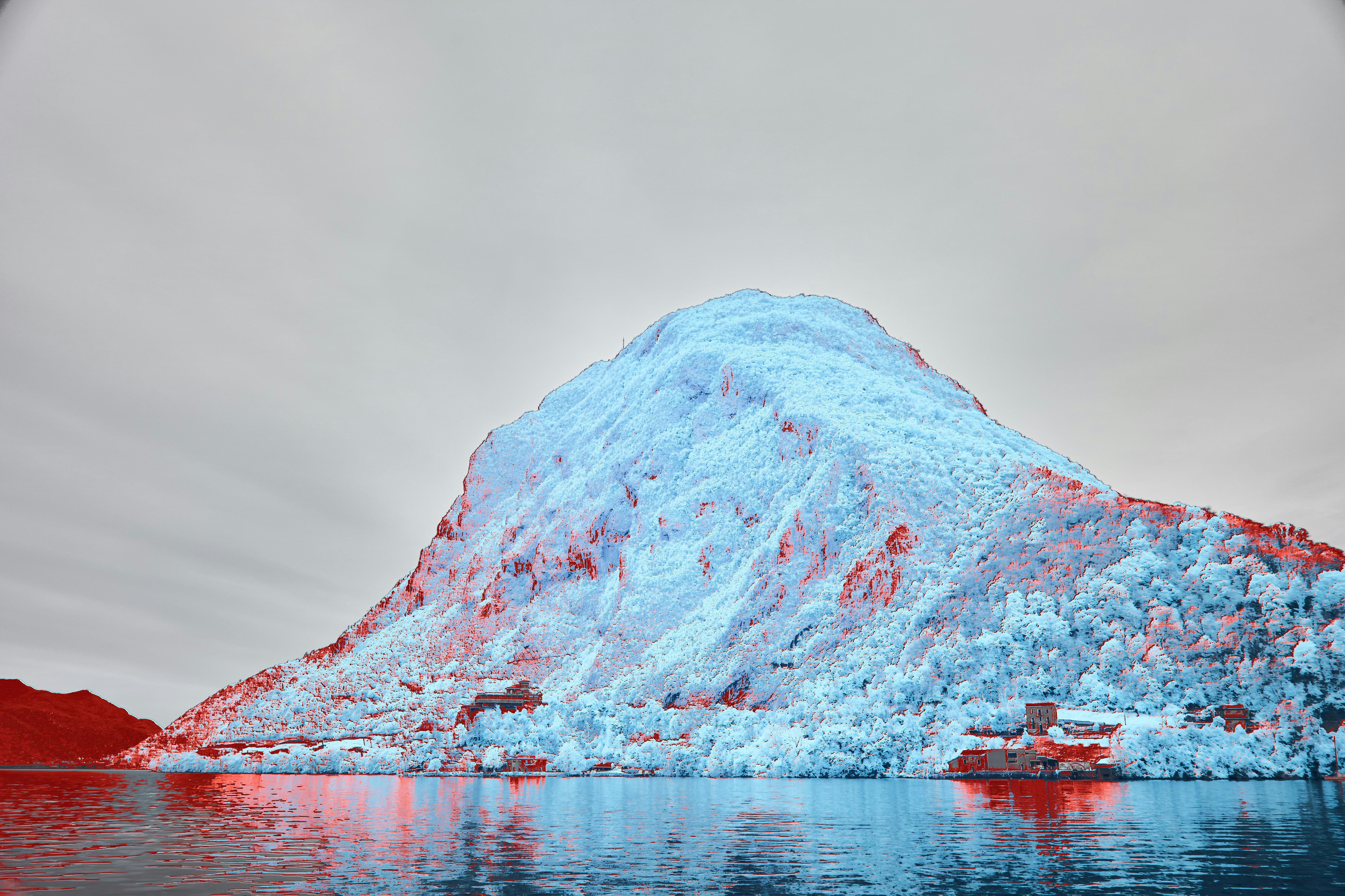 Red-tinted Ice Monolith Ascends Over a Quiet Arctic Harbor
