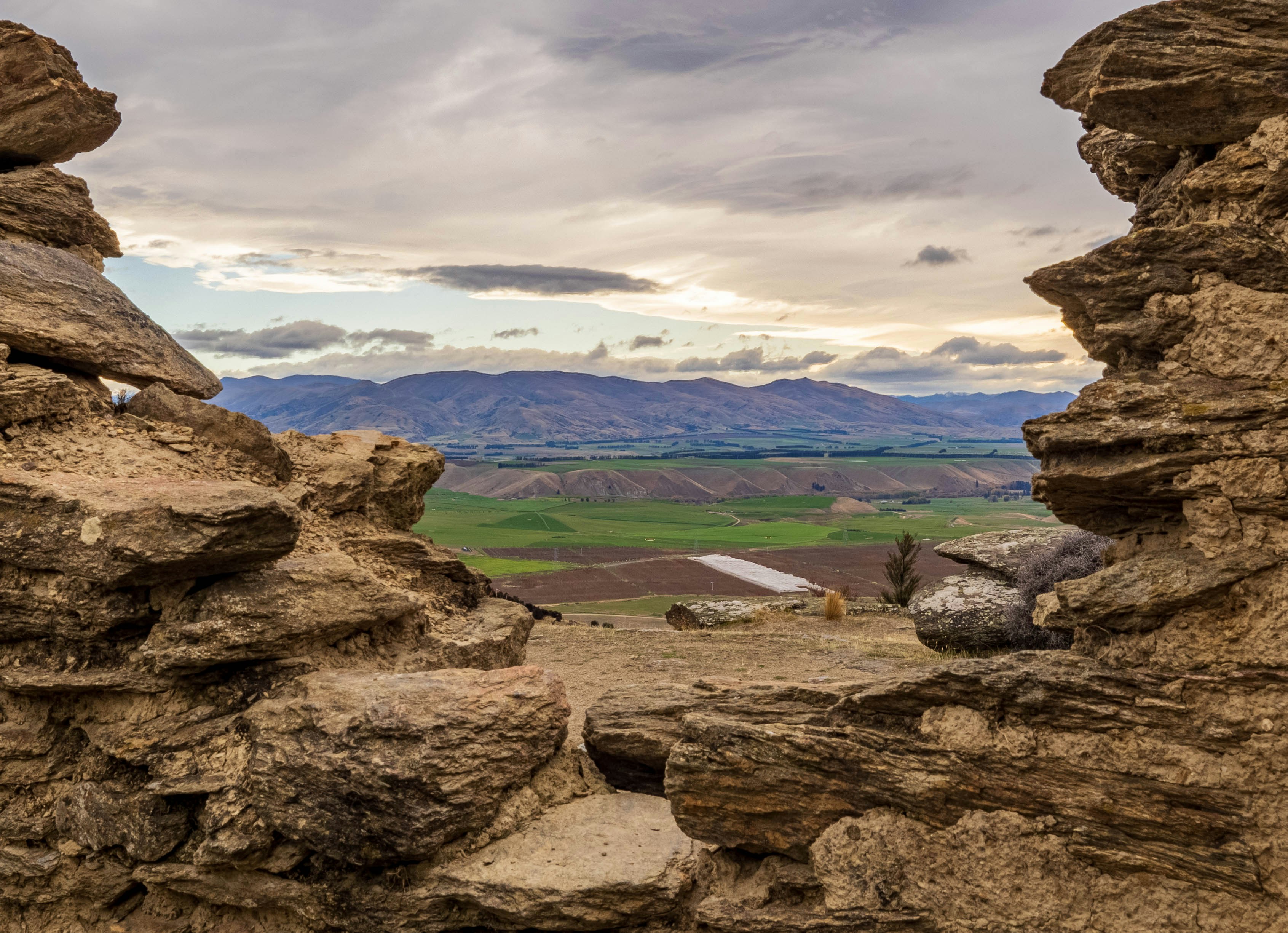 Stone-window Vista: Patchwork Valleys Framed by Ancient Ruins