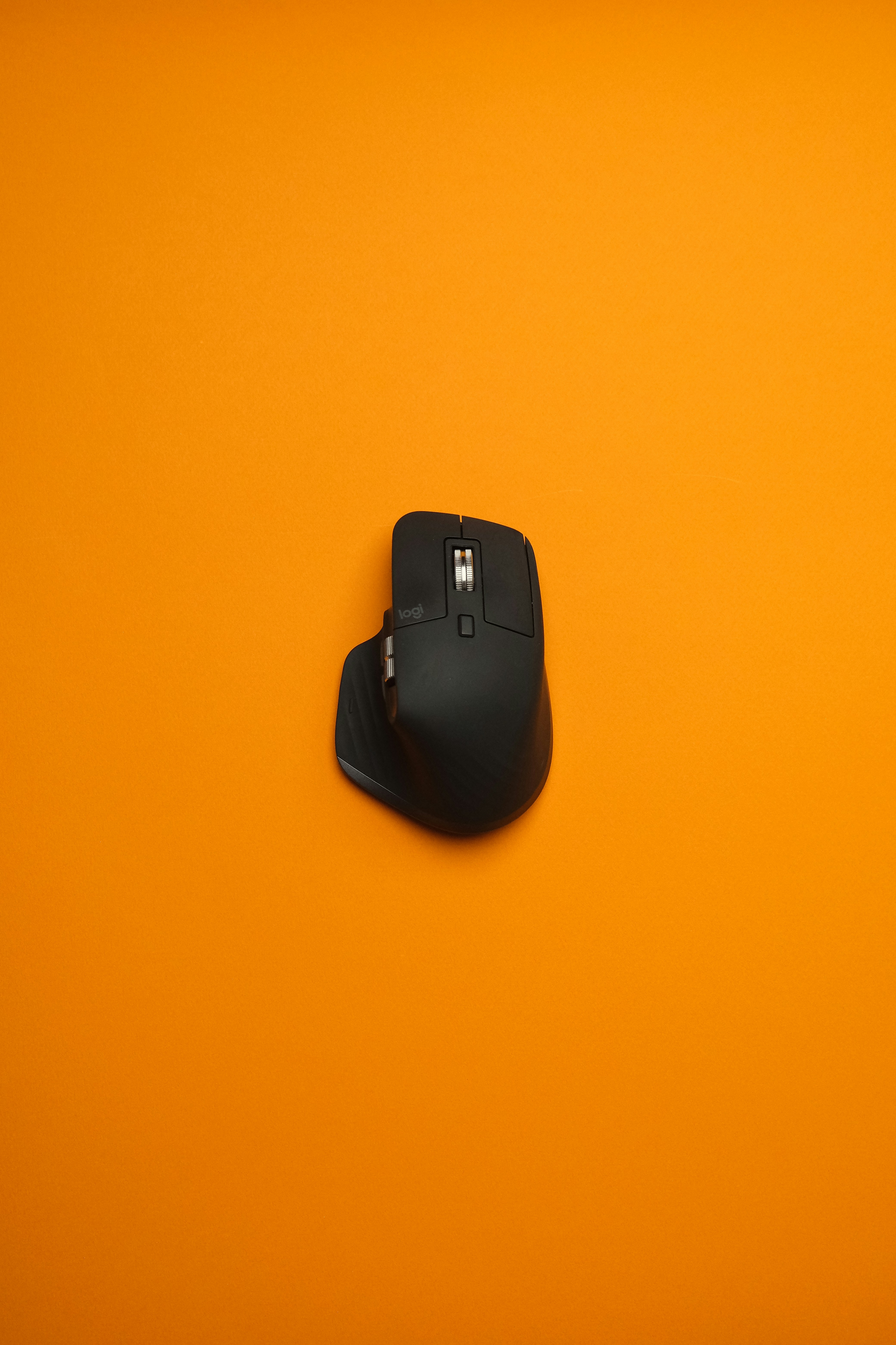 A computer mouse sitting on top of an orange surface photo – Free ...
