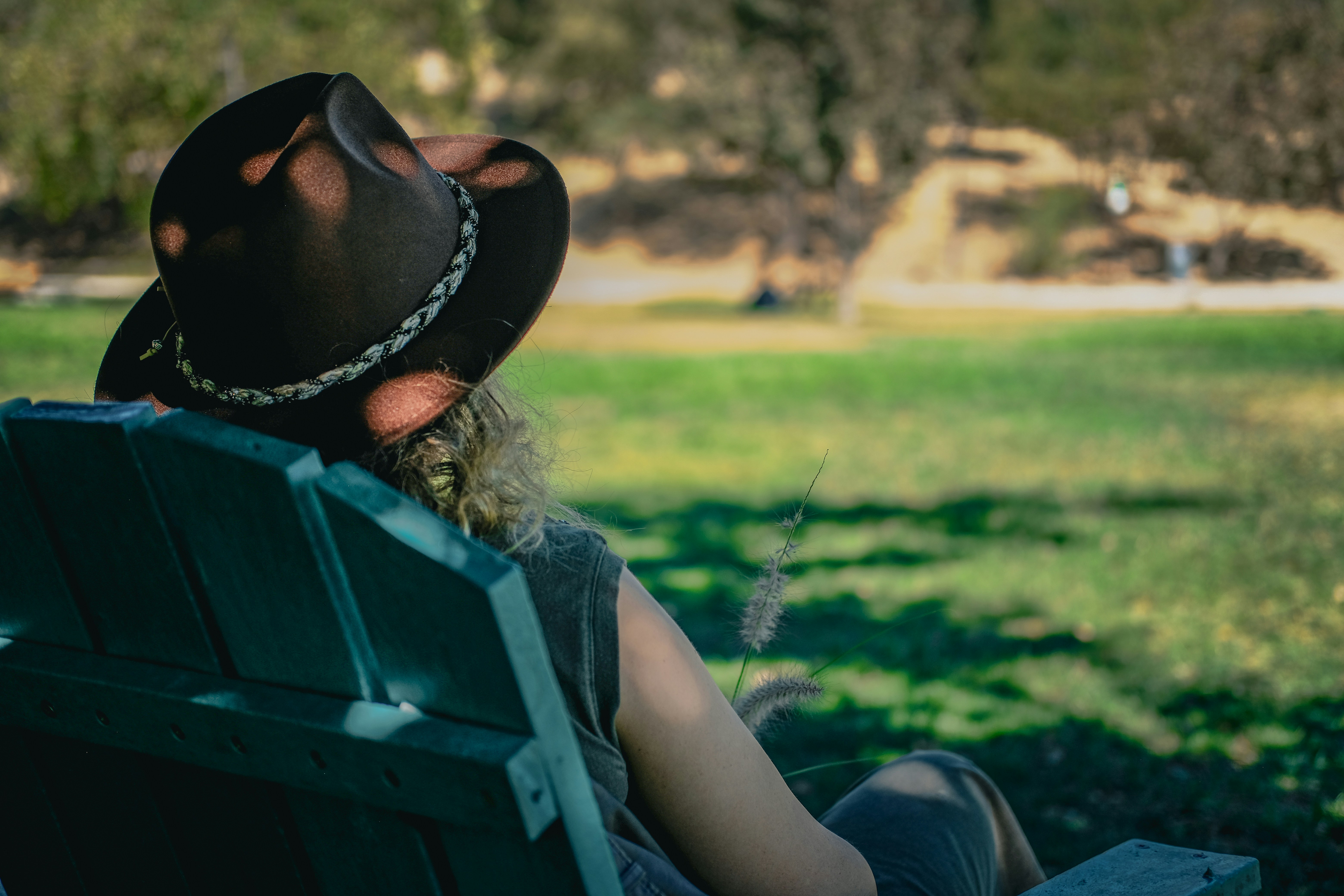 Quiet Afternoon on the Park Bench: Hat, Shadow, and Dappled Light