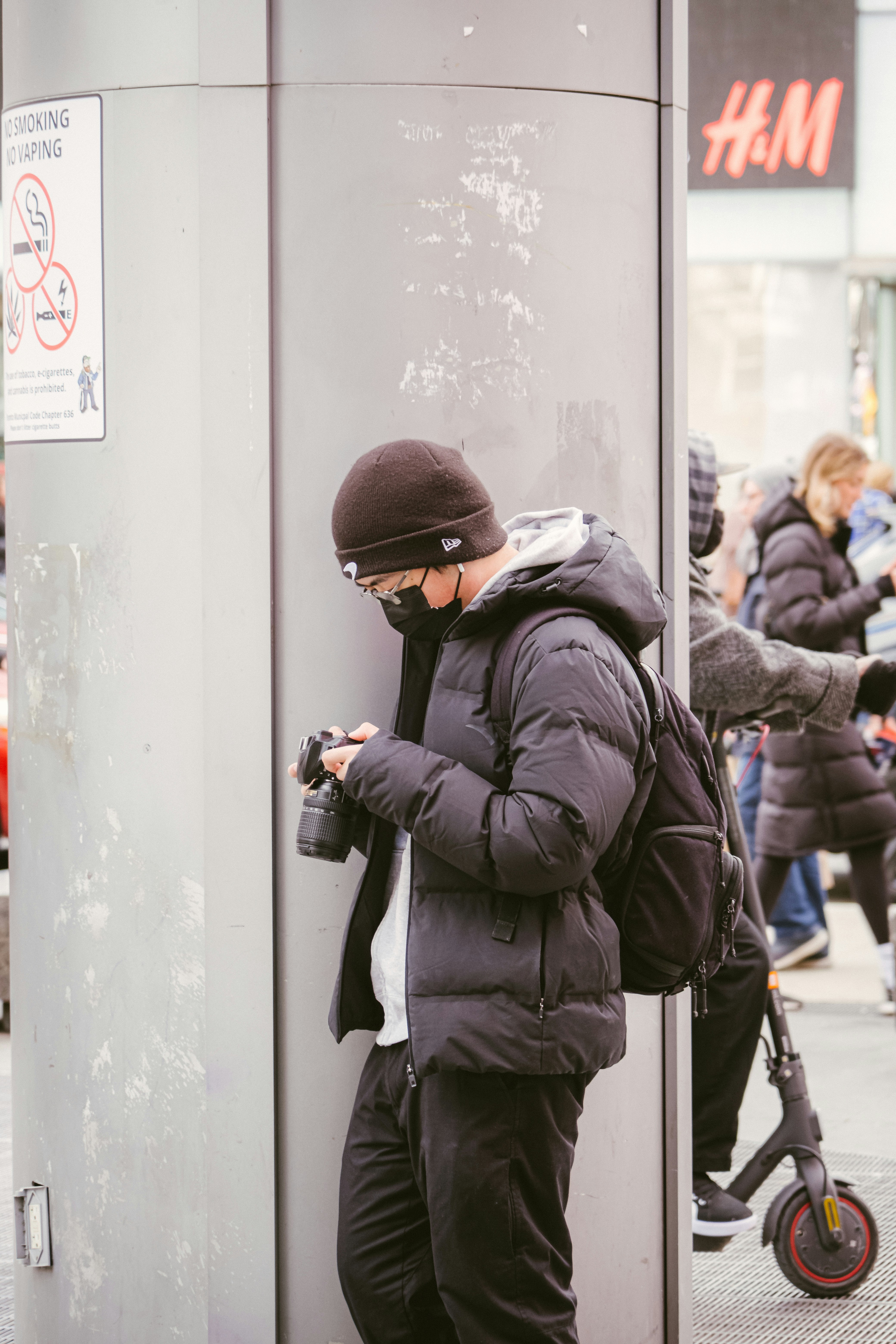A man standing next to a pole on a sidewalk photo – Free Toronto Image ...