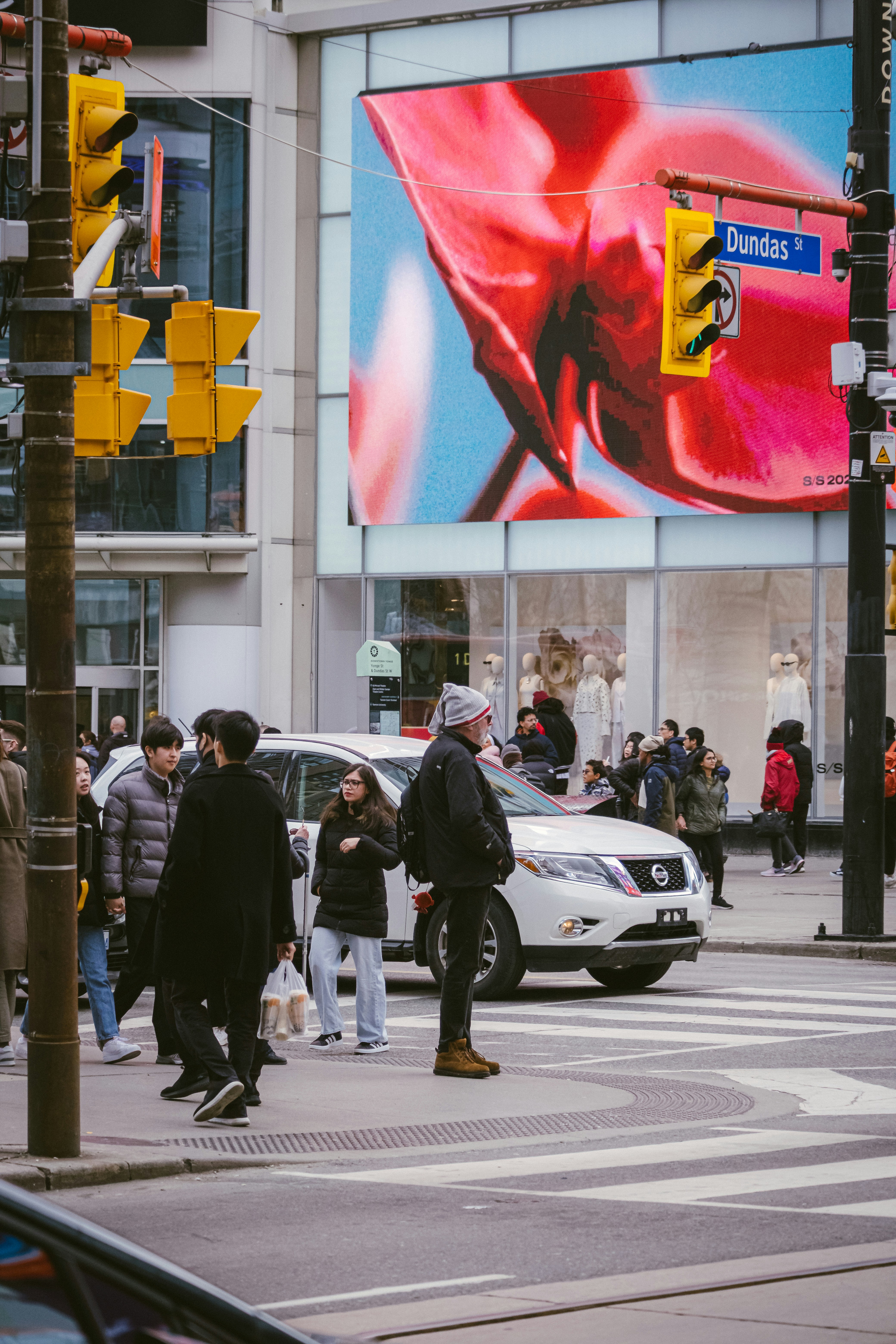 A group of people crossing a street in front of a building photo – Free ...