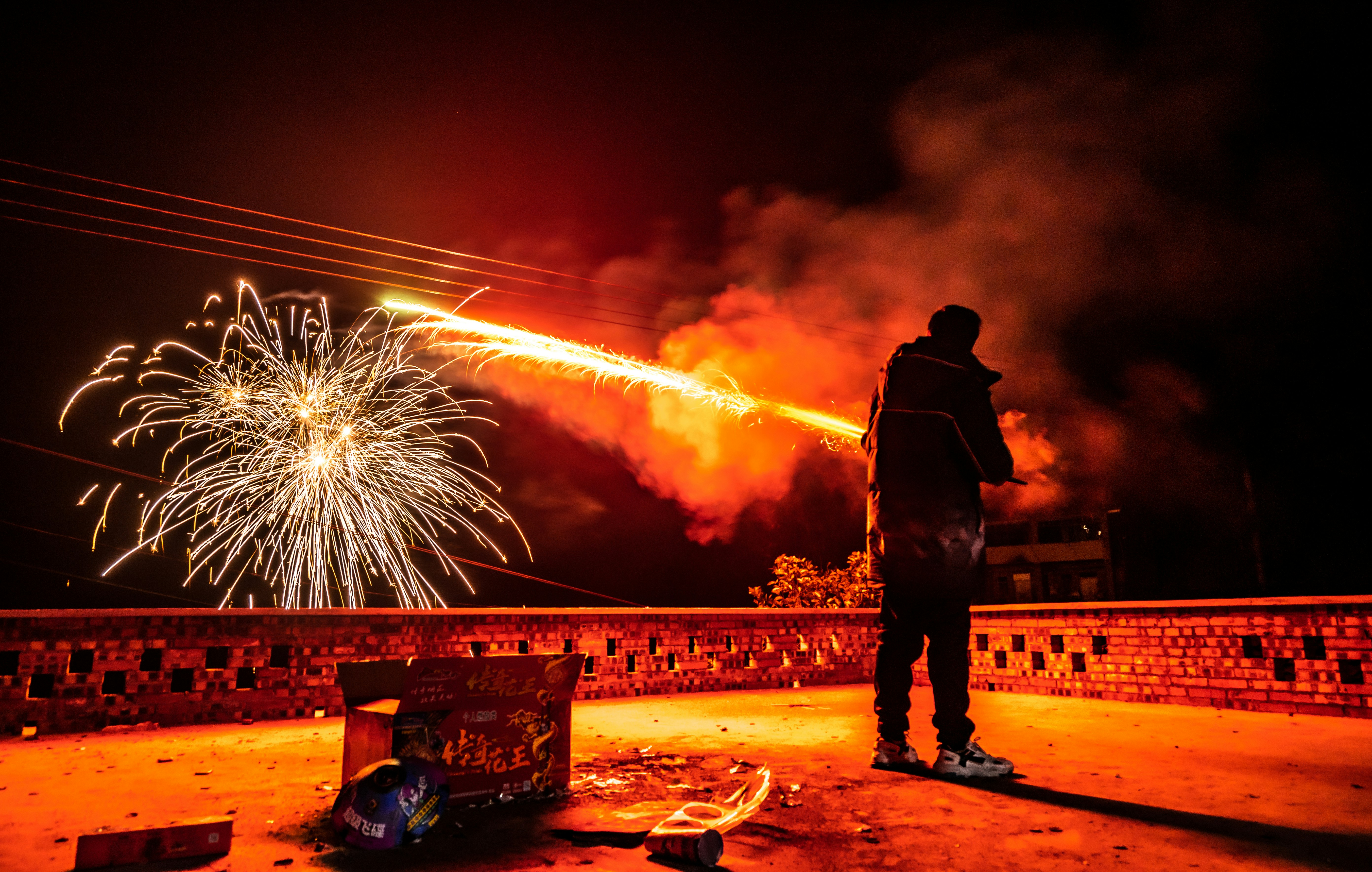 A man standing on a bridge watching fireworks photo – Free Fireworks ...