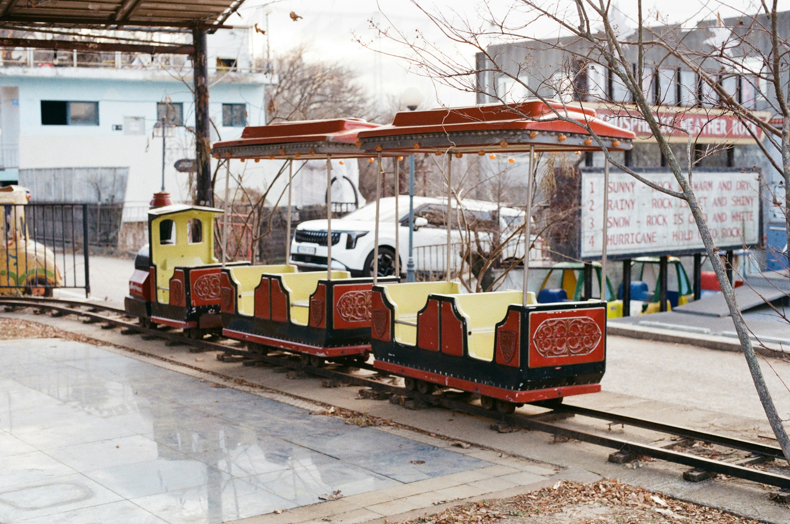 A small train on a track near a building photo – Free Car Image on Unsplash