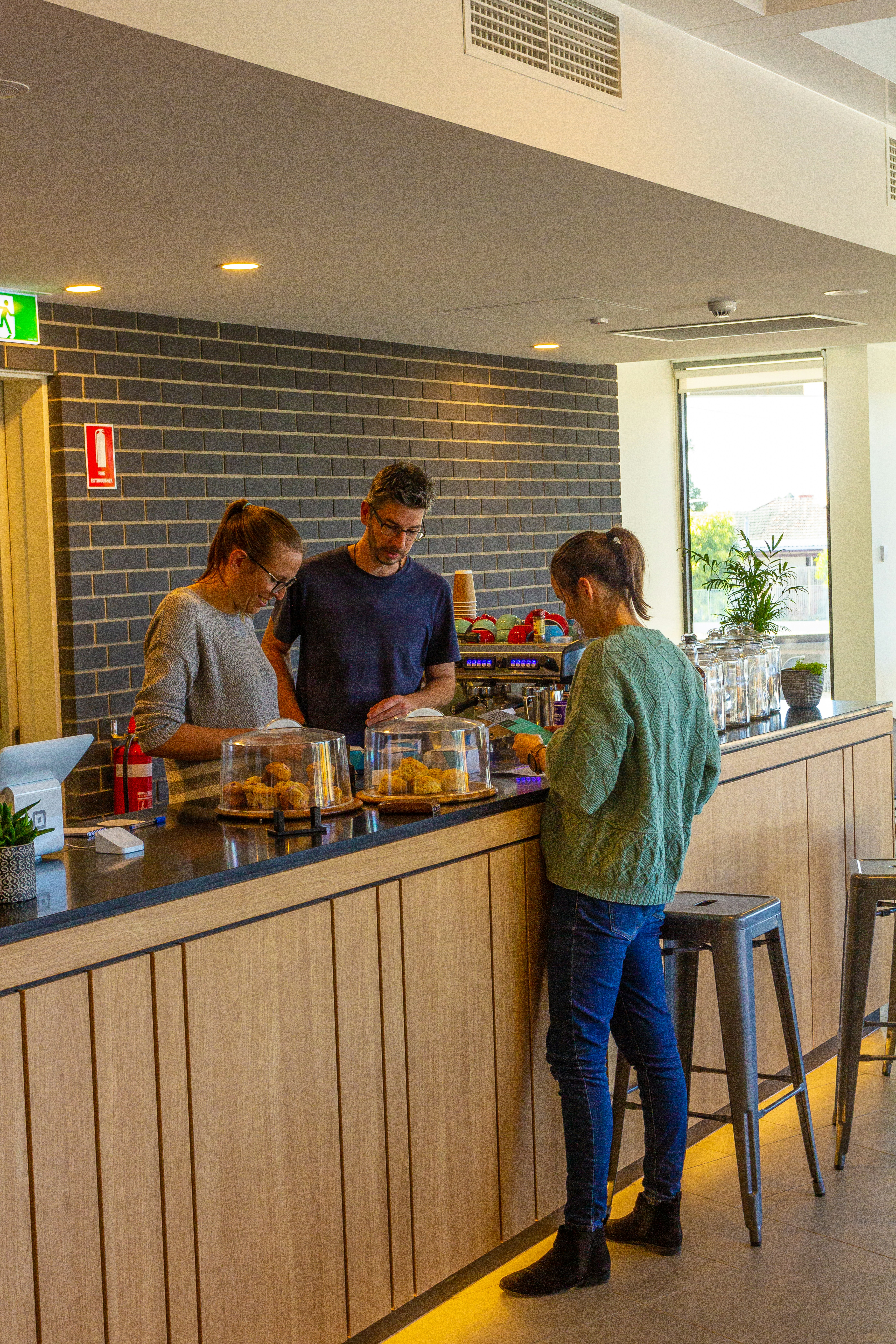 A group of people standing at a counter in a restaurant photo – Free ...
