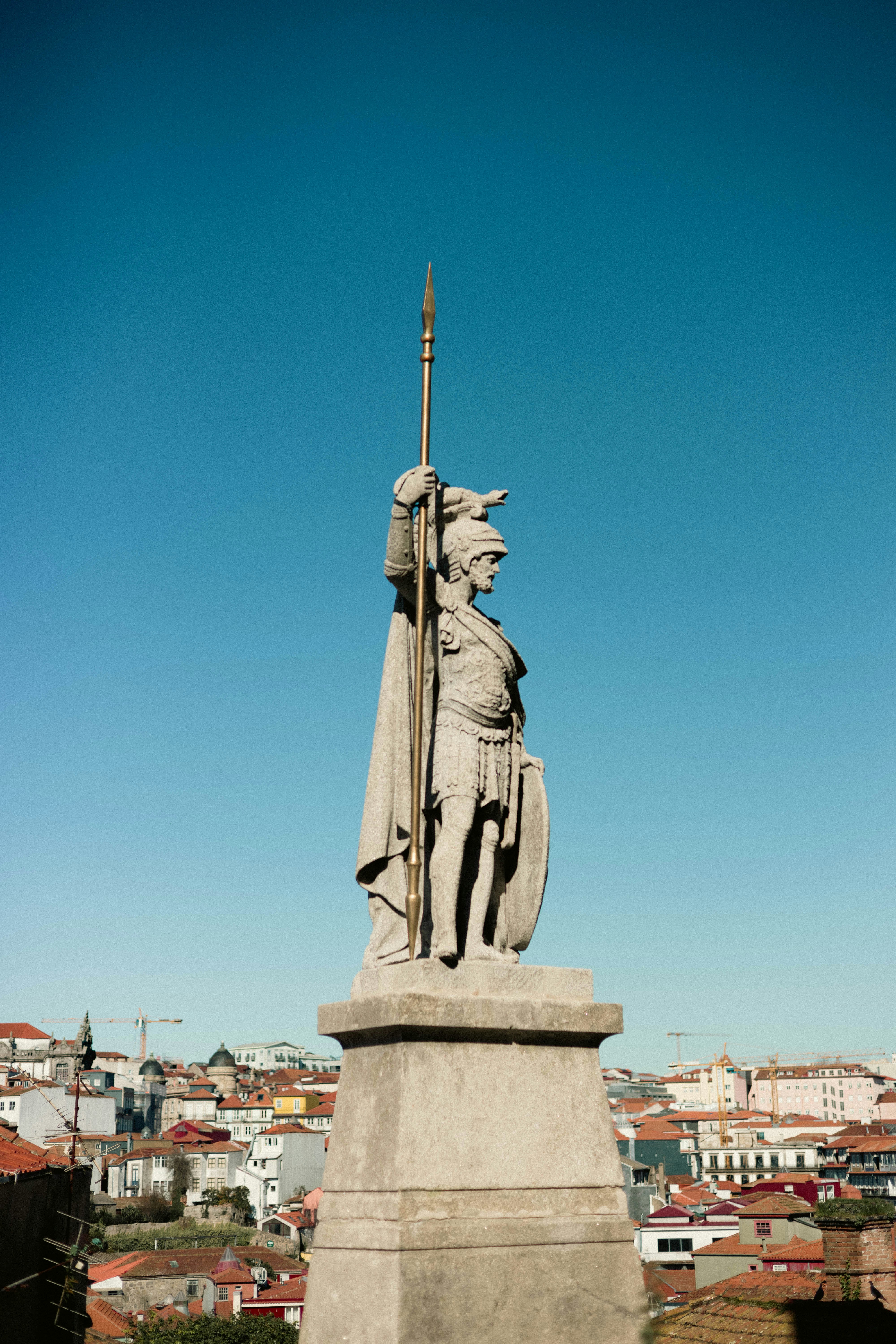 Spear-Bearing Sentinel Over a Rooftiled City
