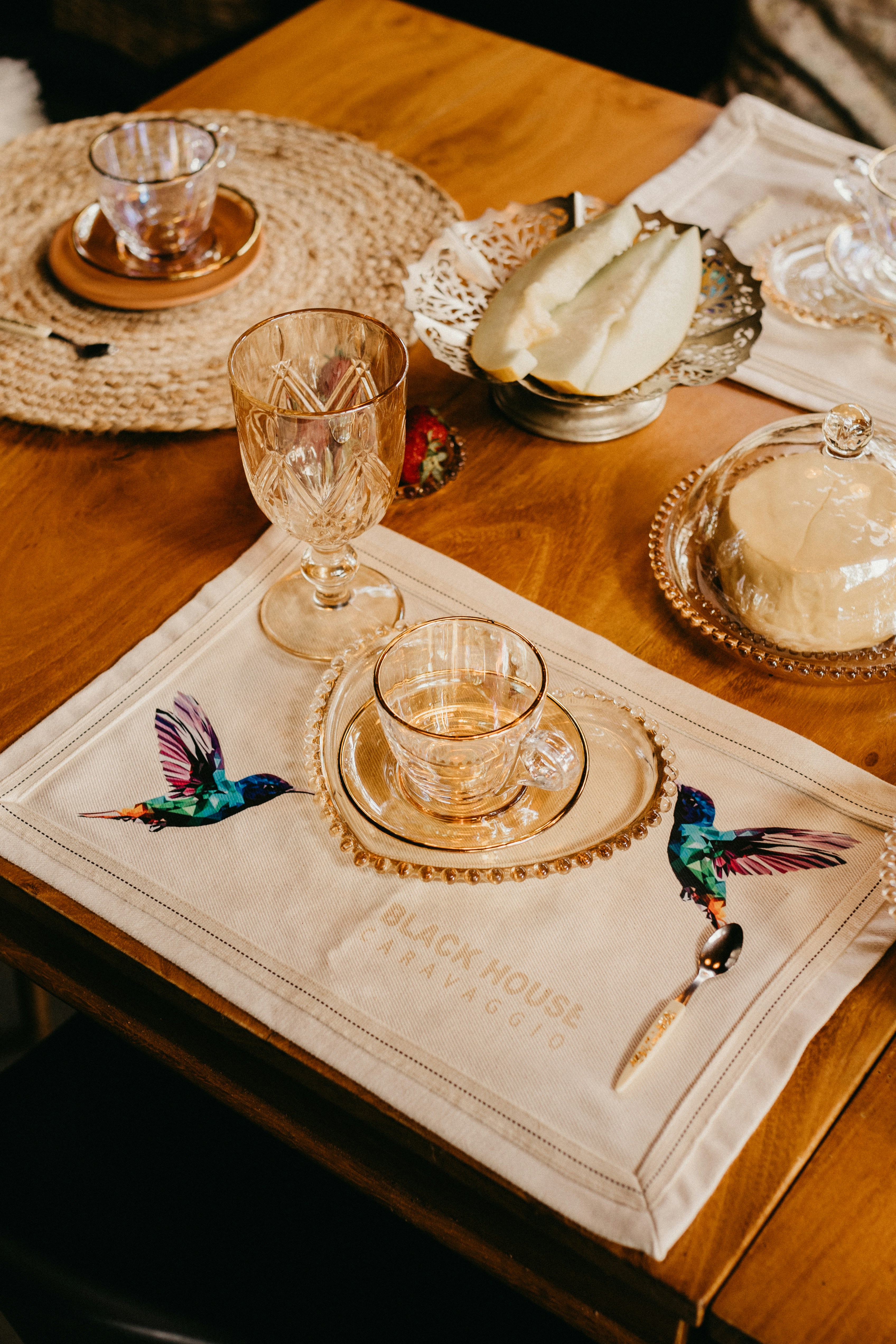 Humble Tablescape: Crystal Glasses and Hummingbird Motifs on a University White Napkin
