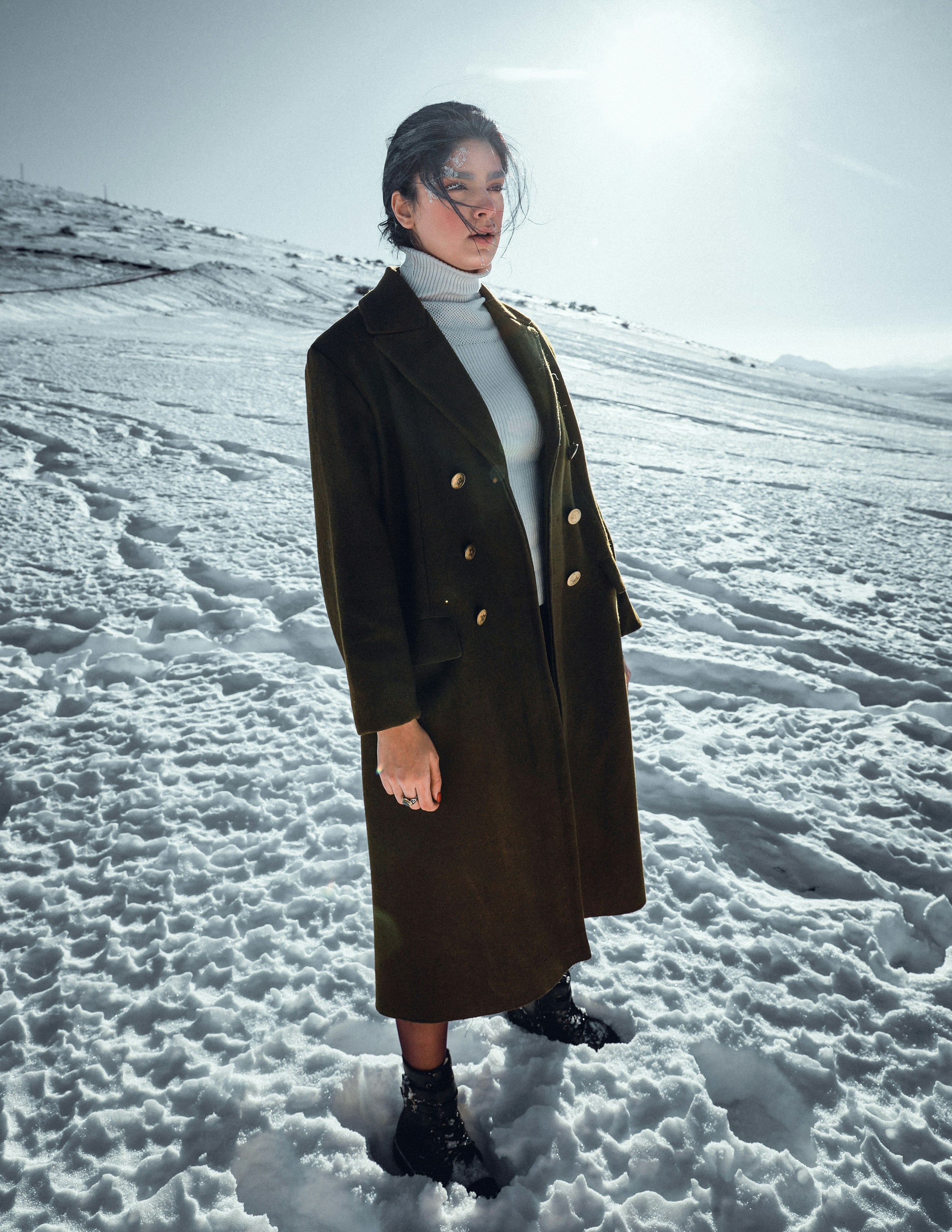 Winter Silhouette: A Dark Coat Beneath a Bleached Sun