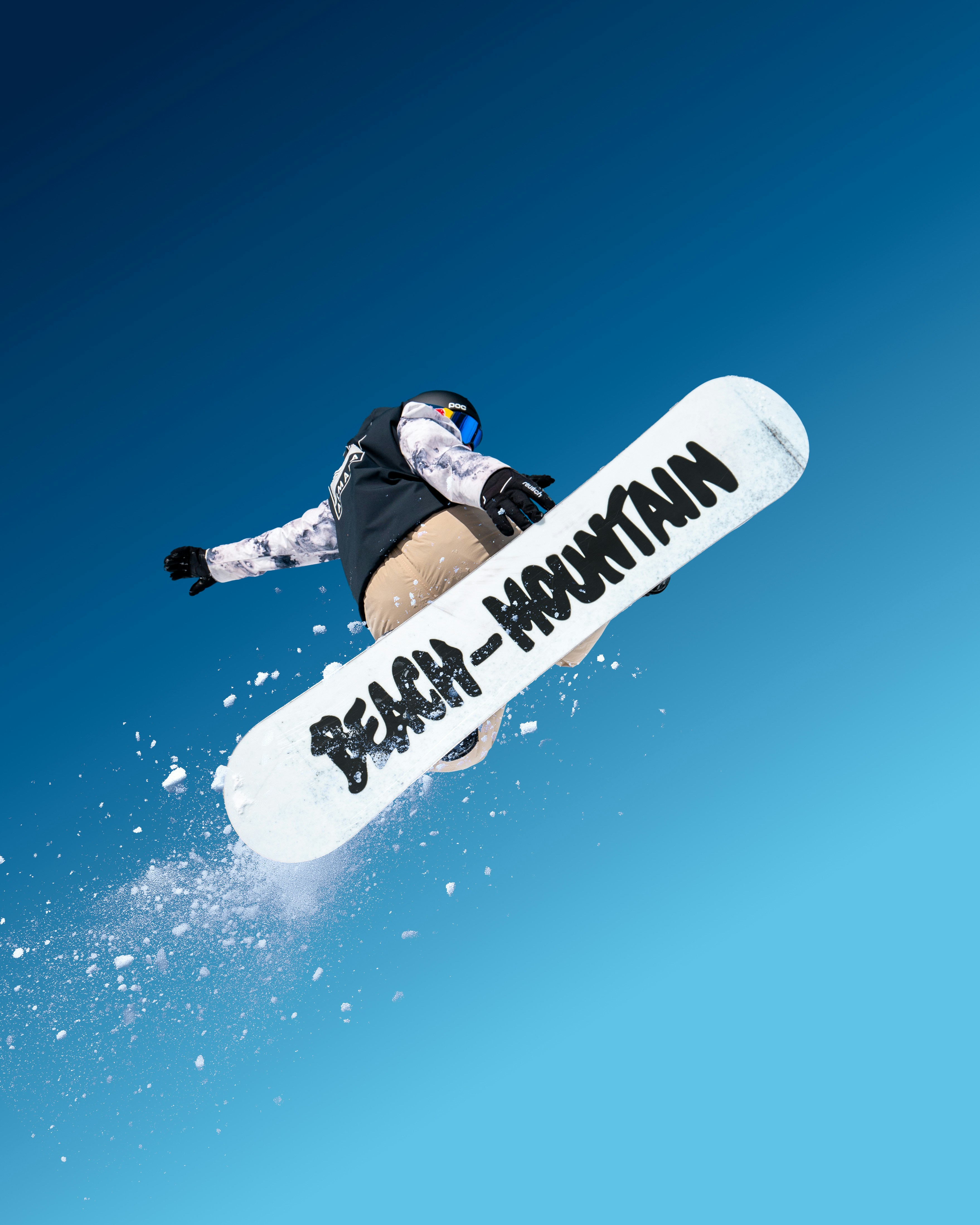 A man flying through the air while riding a snowboard photo – Free Snow ...