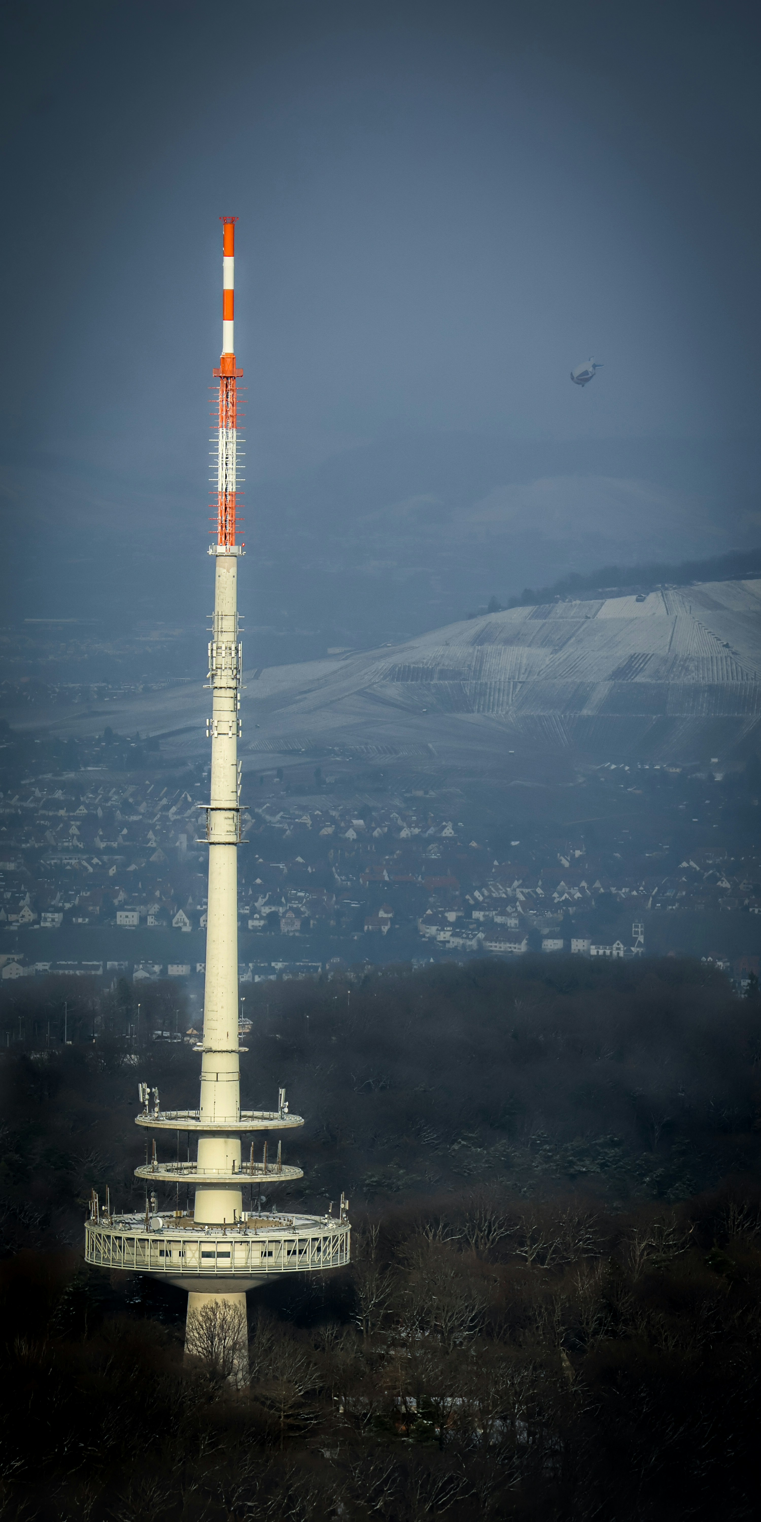 Red-and-White Beacon Above a Snow-Dusted Valley