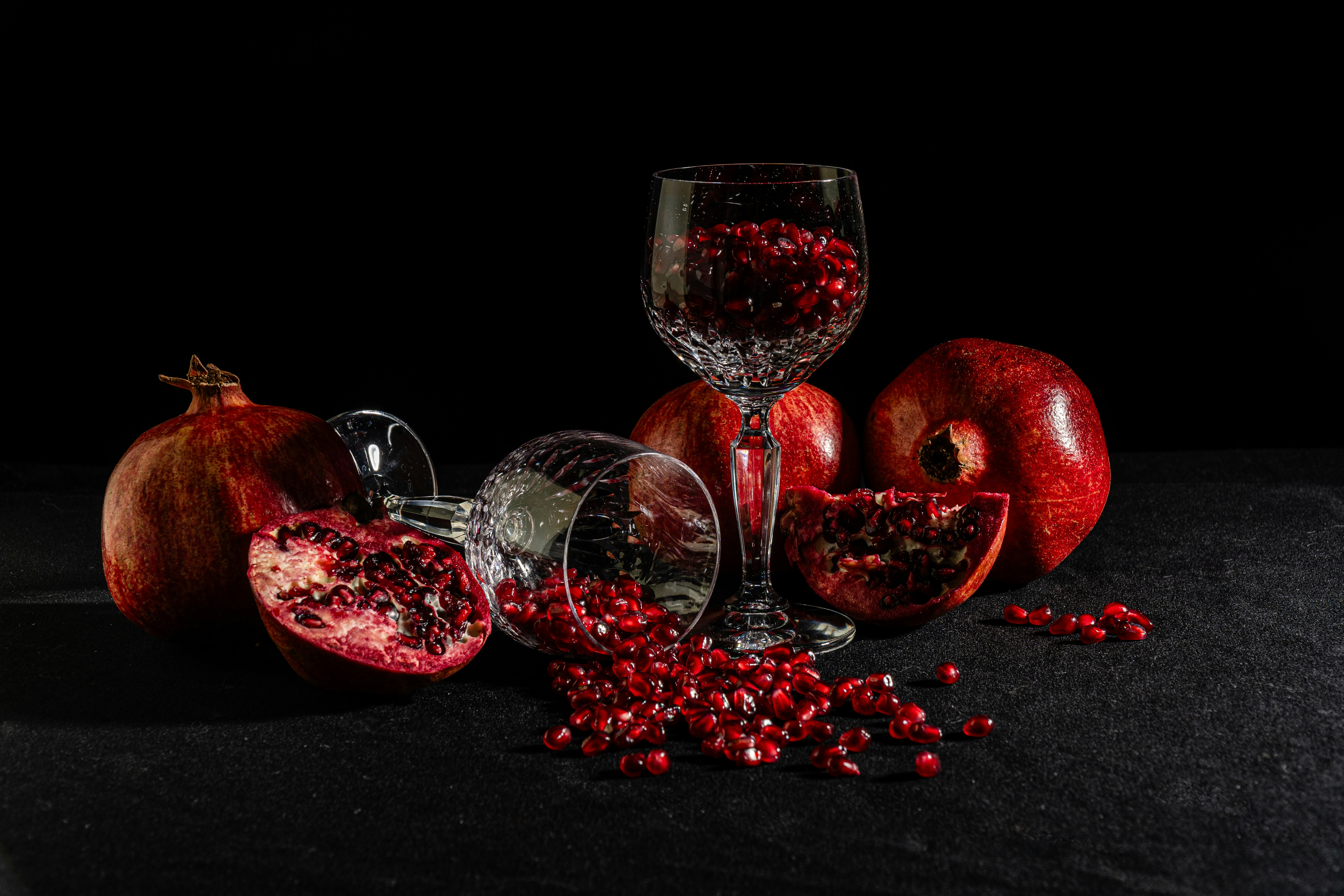 A glass of wine and some pomegranates on a table photo – Free Food ...