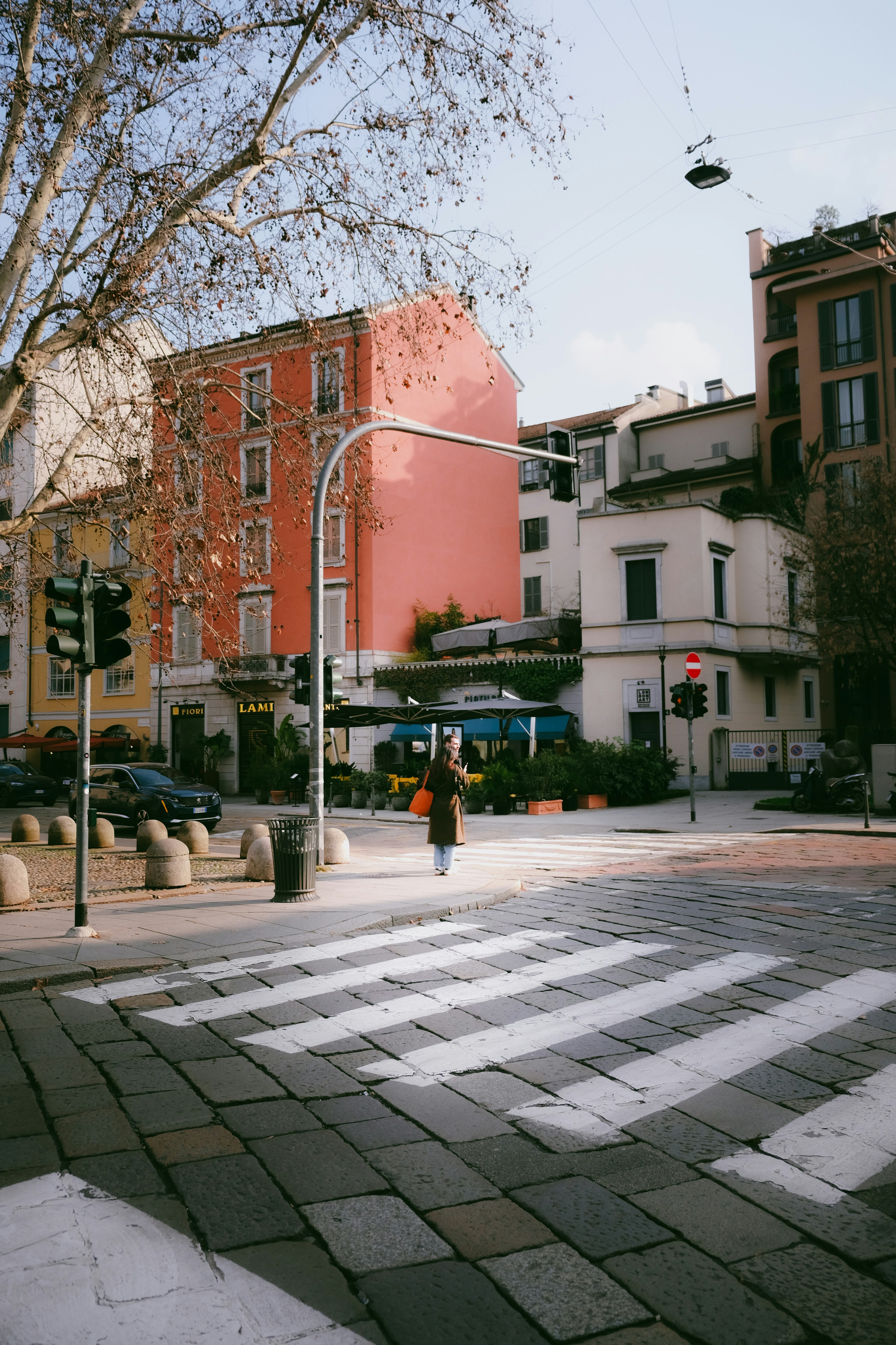 A person walking across a cross walk in the middle of a city photo ...