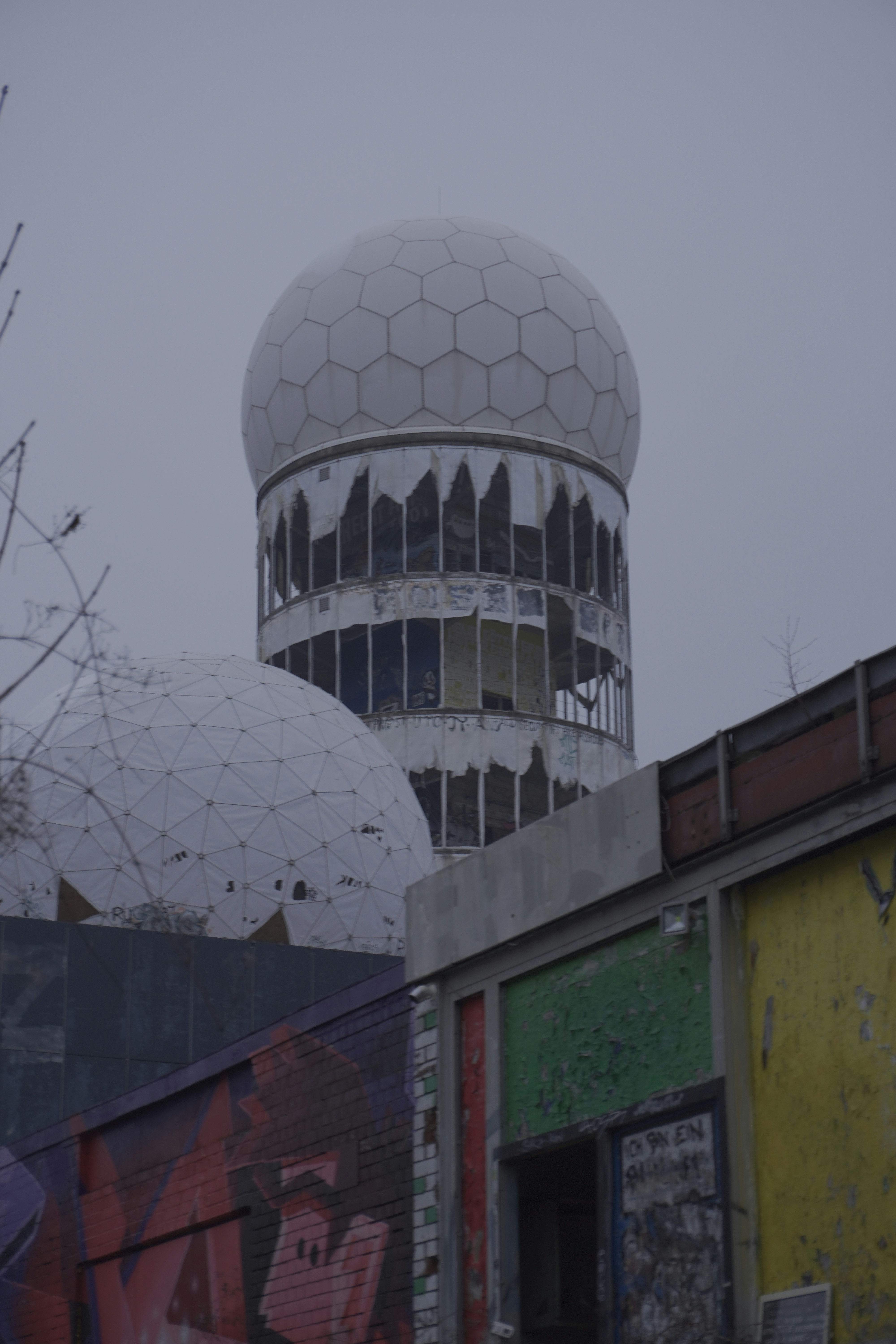 Industrial radar dome silhouettes against a misty urban skyline