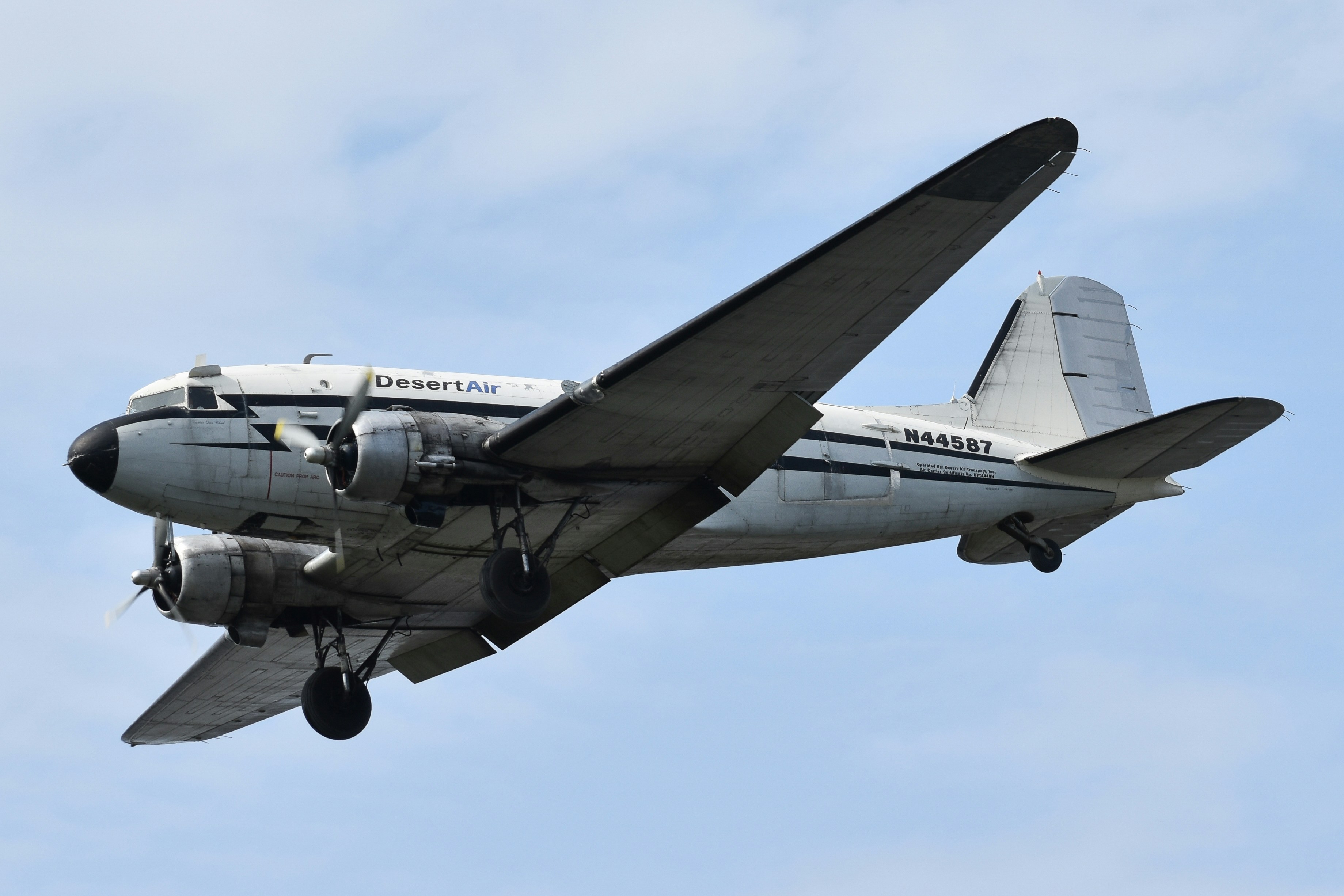 Desert Air DC-3 aircraft approaching Anchorage under a clear sky.