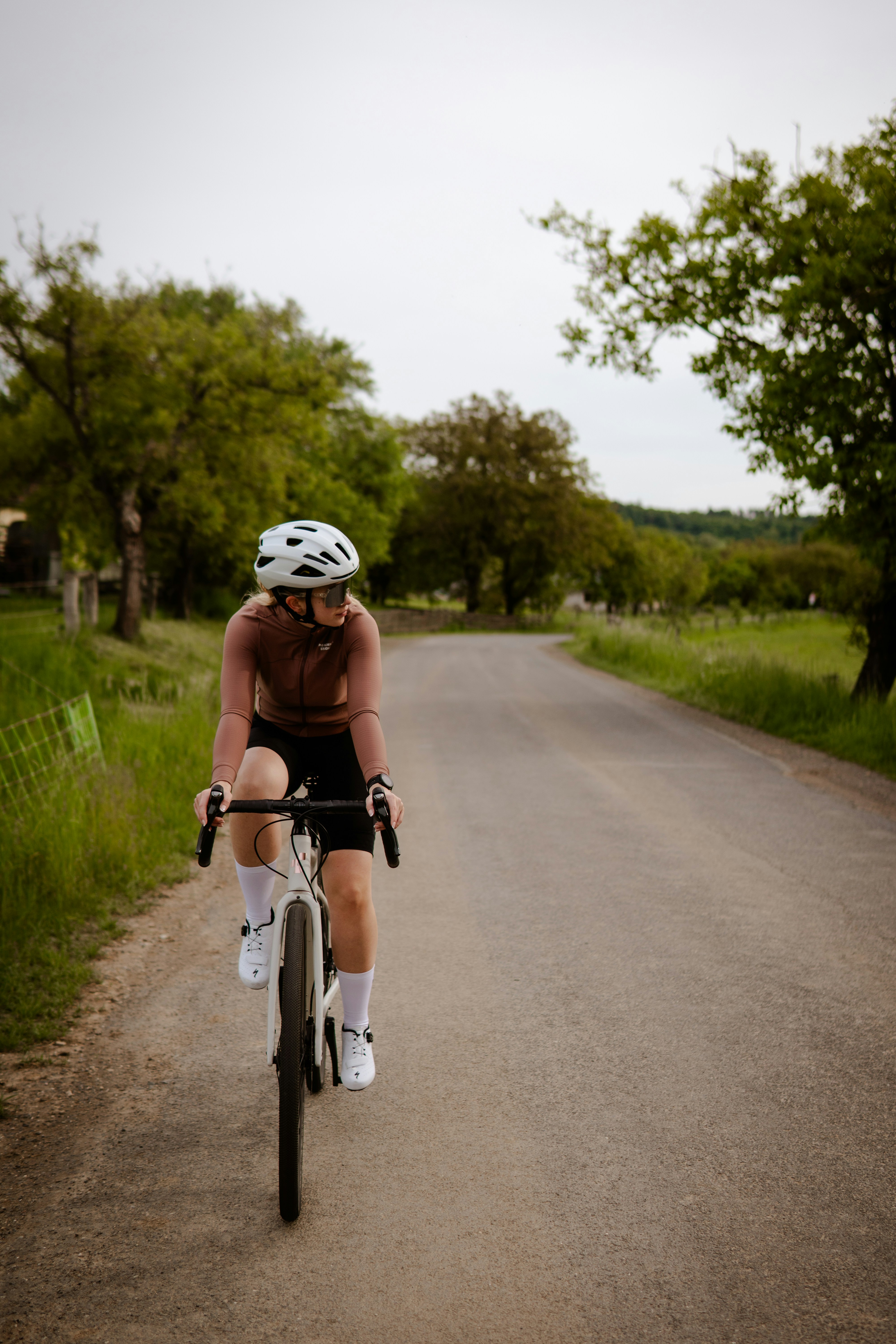 A woman riding a bike down a country road photo – Free Woman Image on ...
