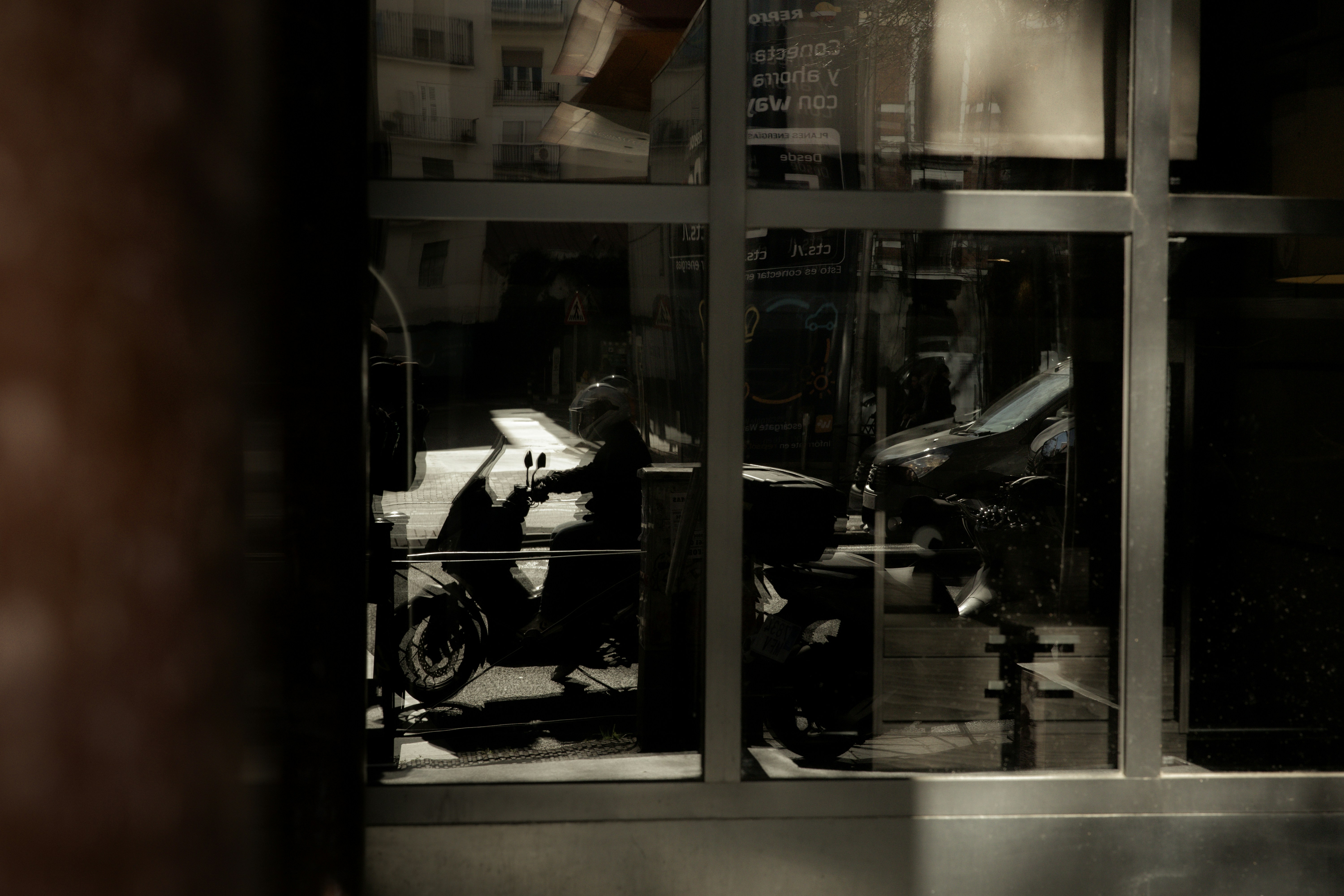 A motorcycle parked in front of a window photo – Free Building Image on ...