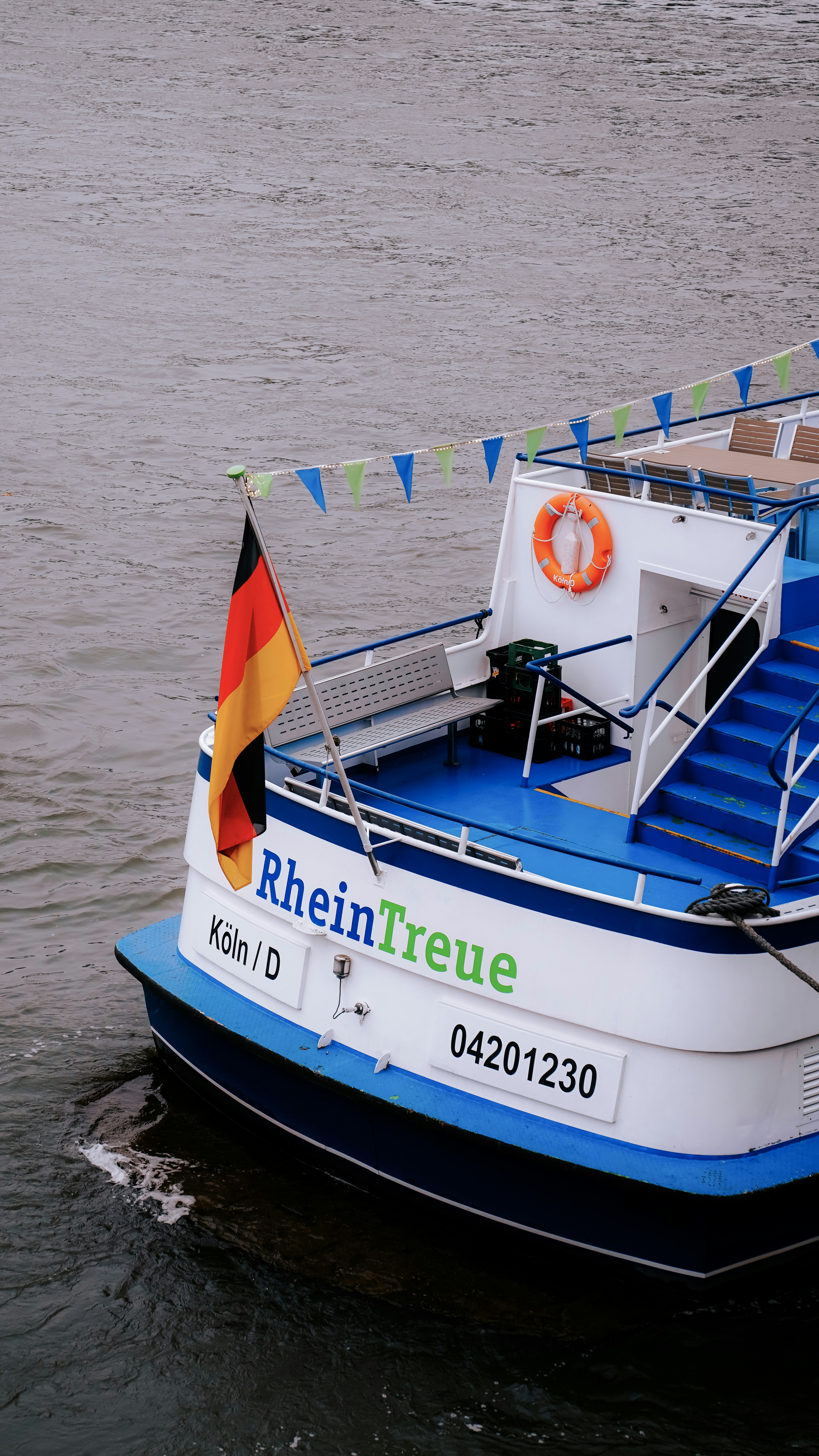 RheinTreue at the Rhine: Festive flags frame a blue-and-white riverboat