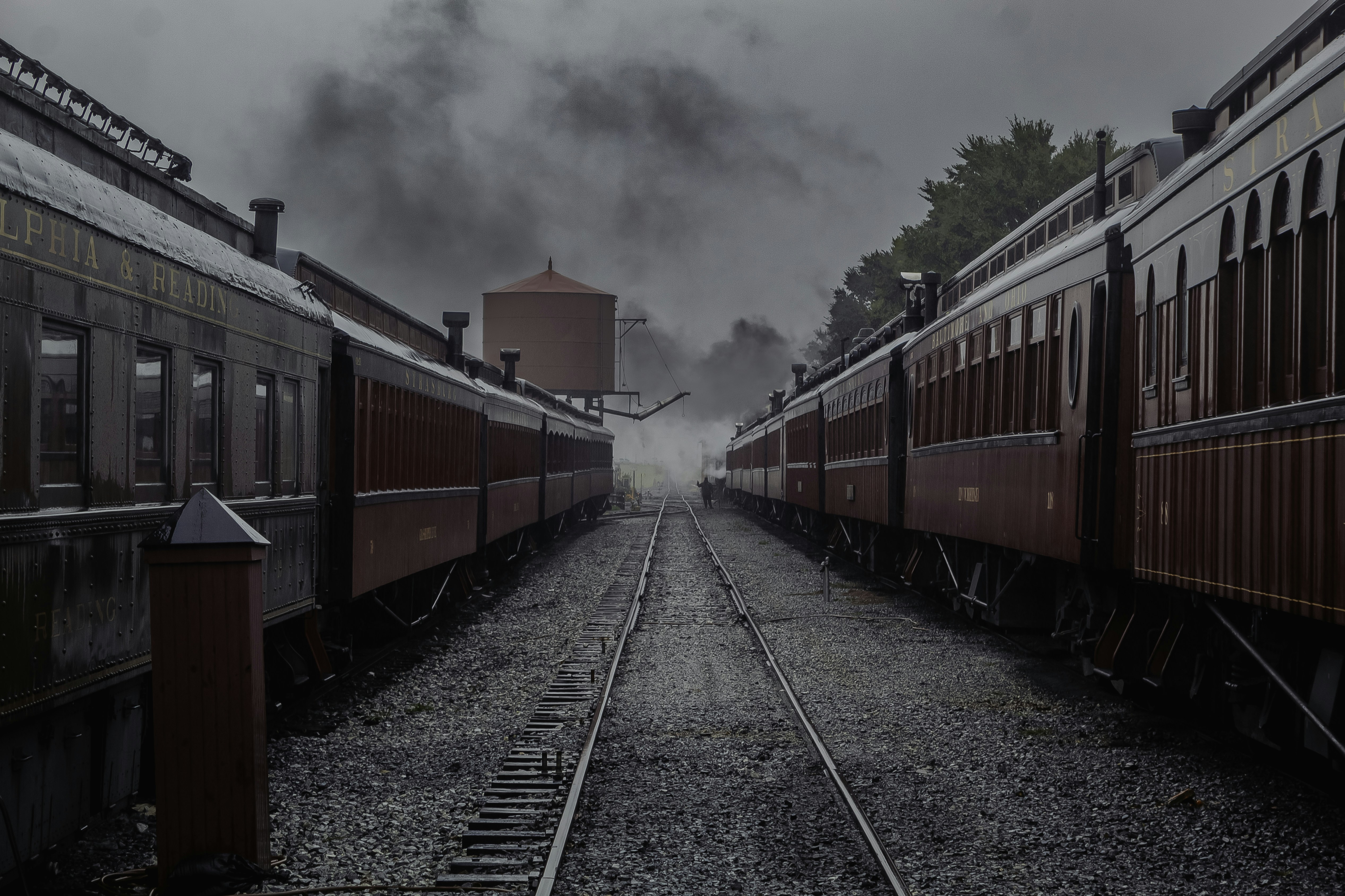 A row of red trains sitting next to each other on train tracks photo ...
