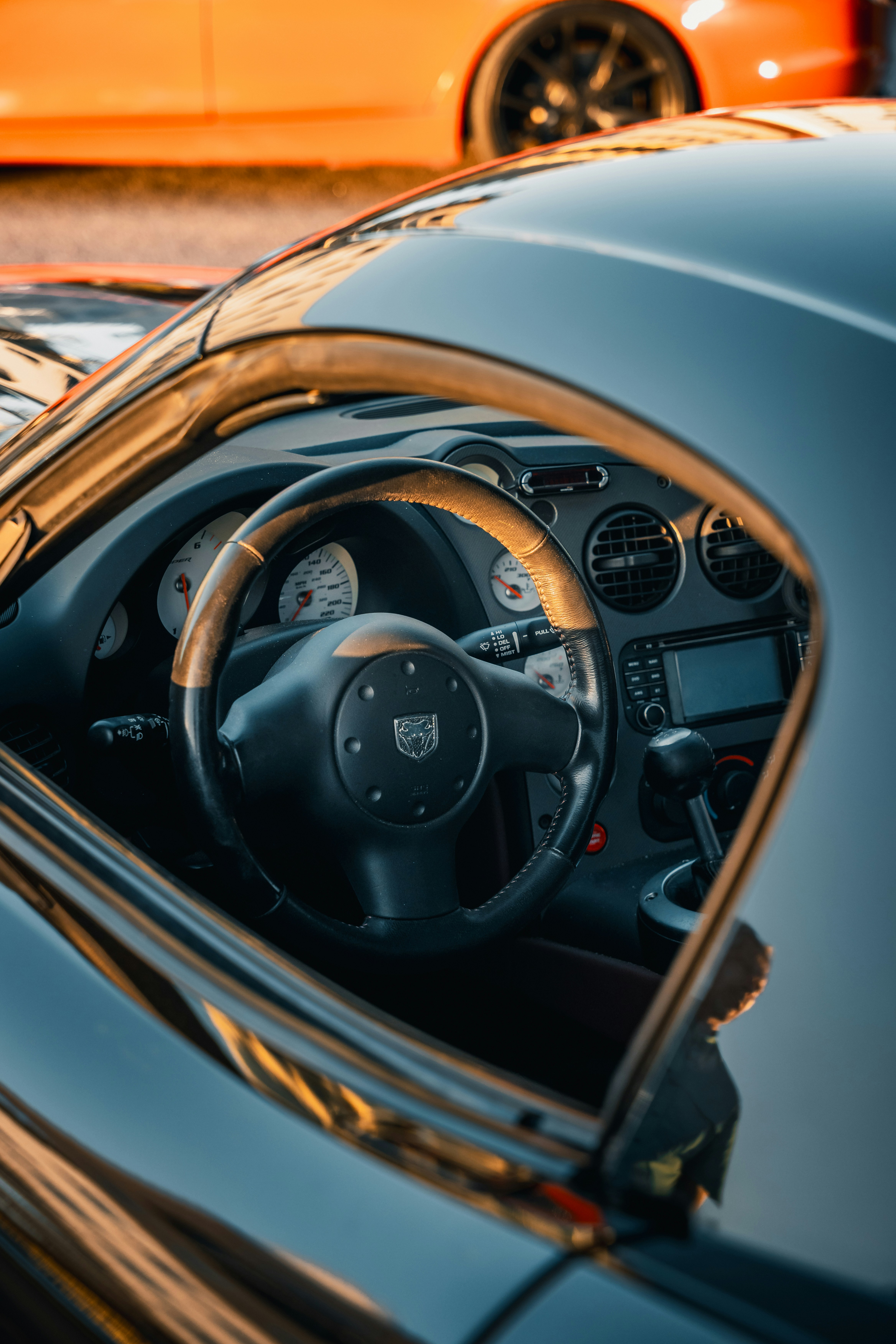 Close-Up Cockpit Portrait: Leather-Wrapped Steering Wheel in Golden Light