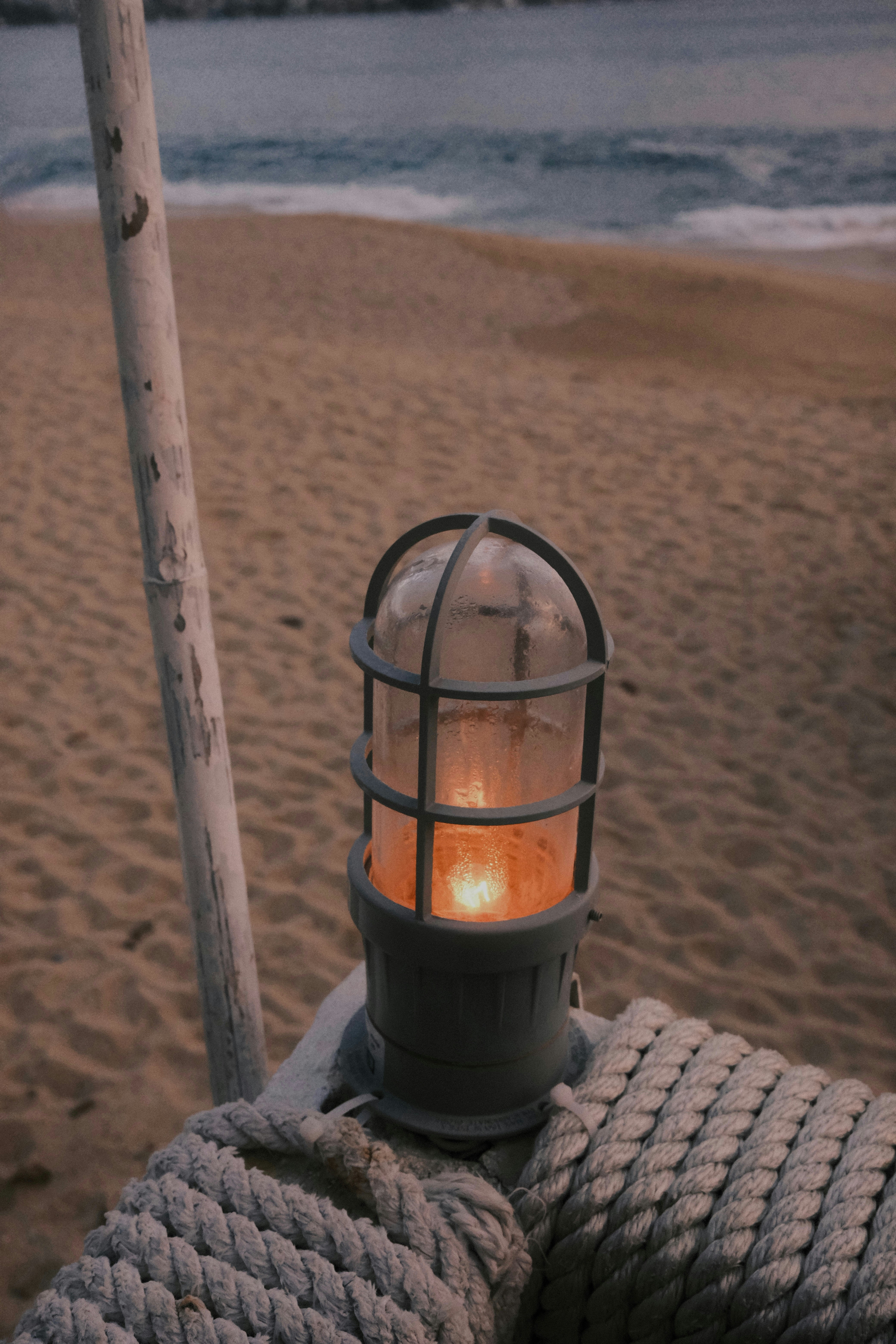 Lantern on a Coiled Rope: A Dusk Moment Along the Beach