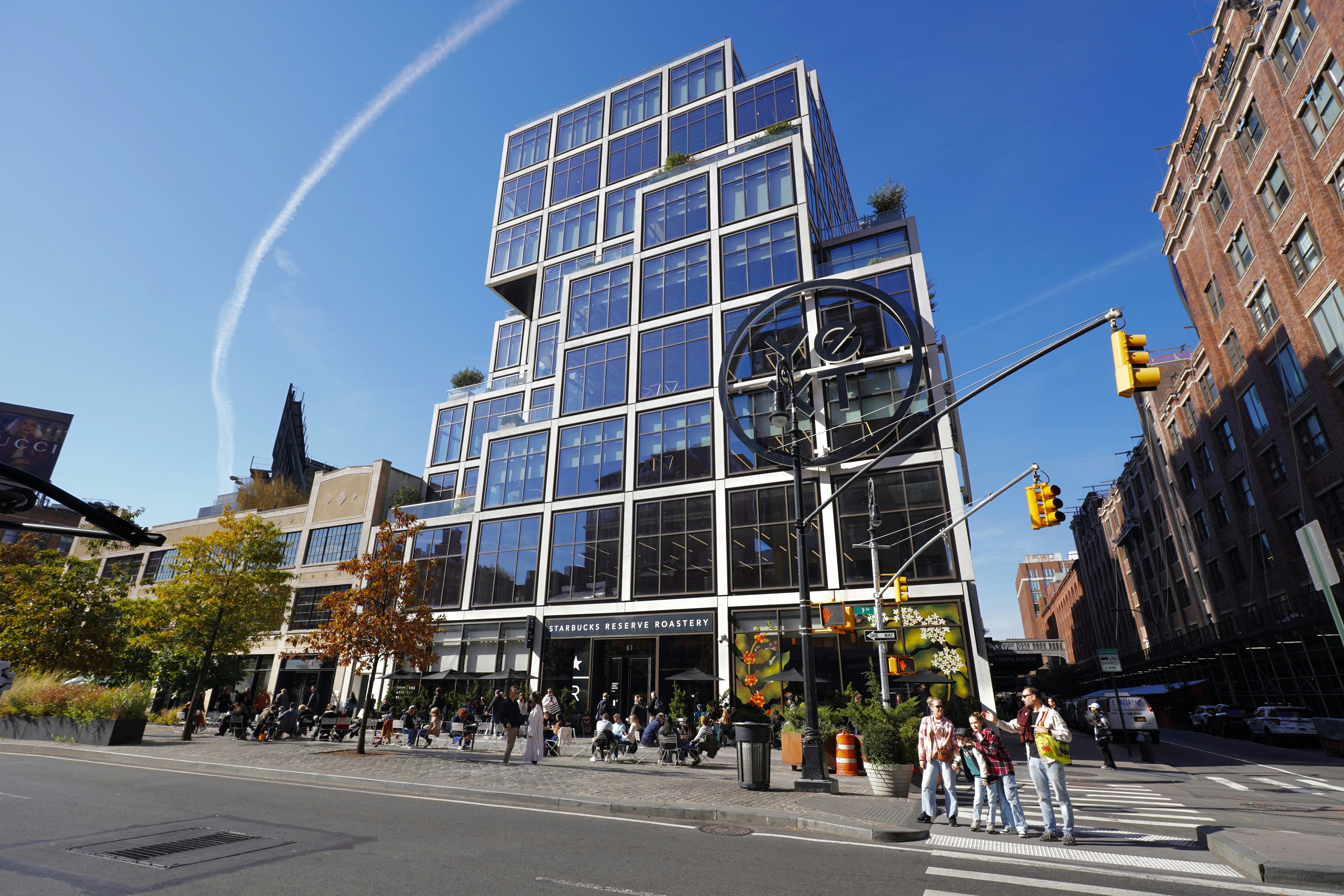 A group of people crossing a street in front of a tall building photo ...