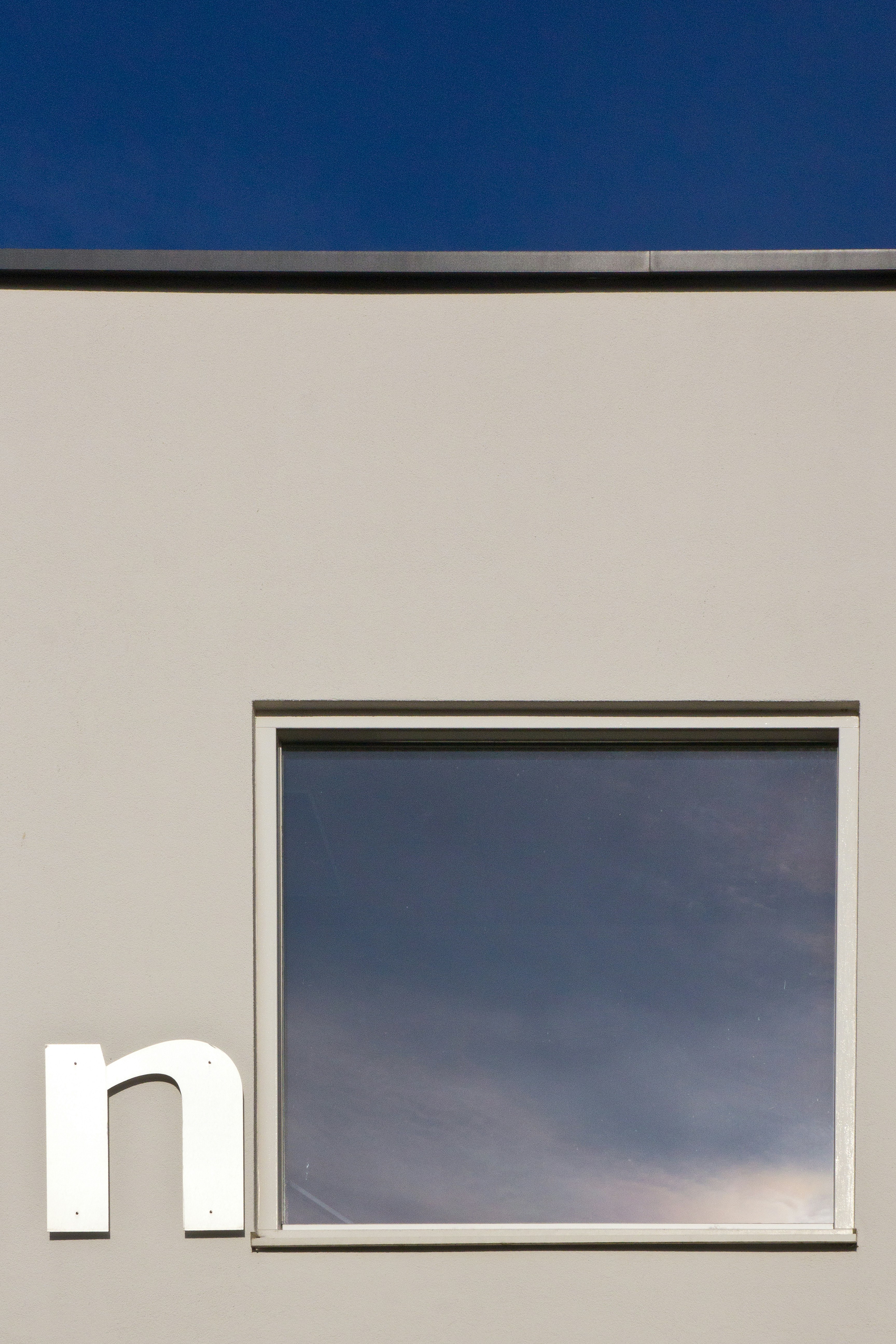 Window Reflection on a Minimal Beige Facade