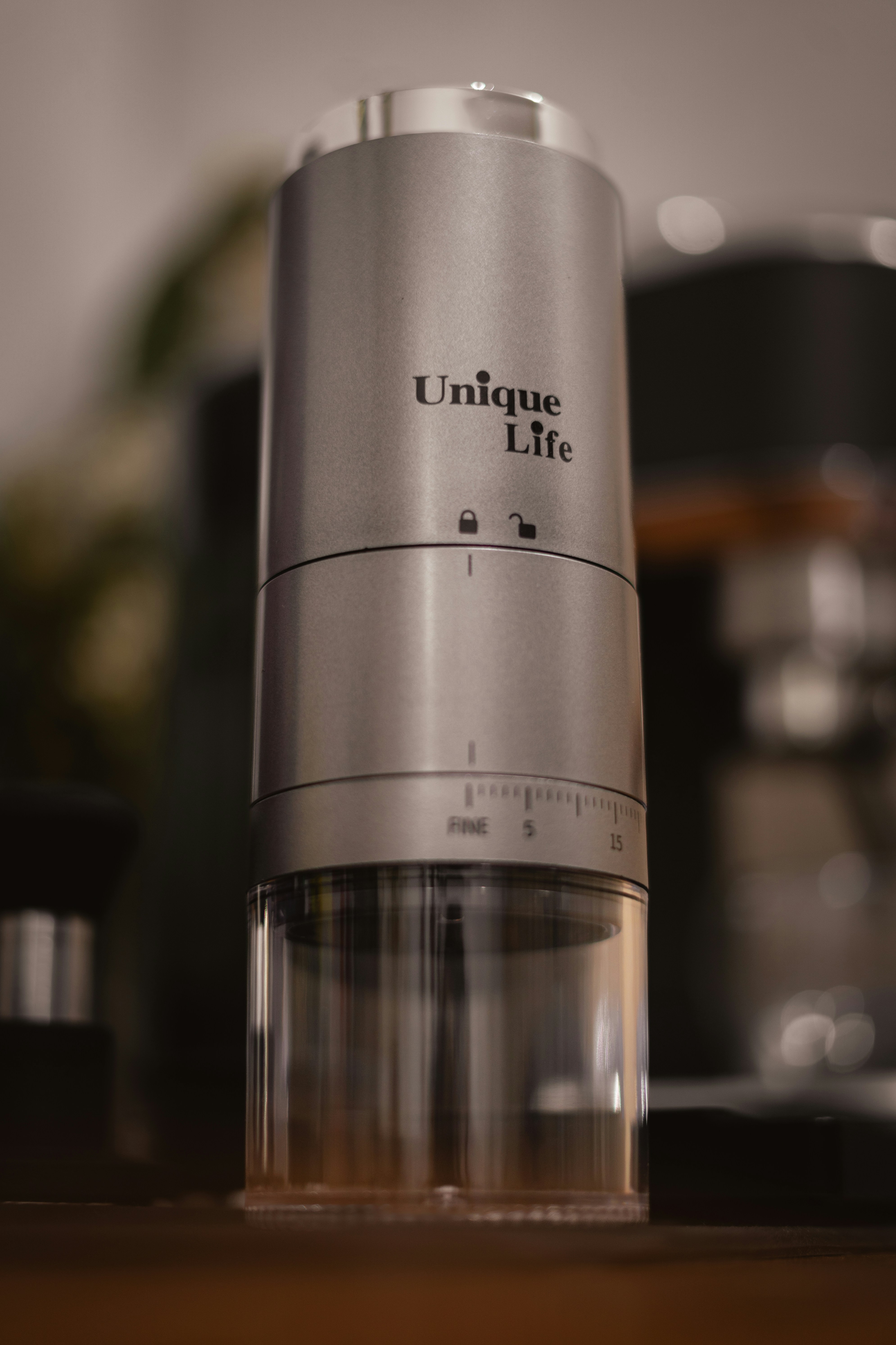 Macro portrait of a Unique Life coffee grinder's metallic dial under warm studio light