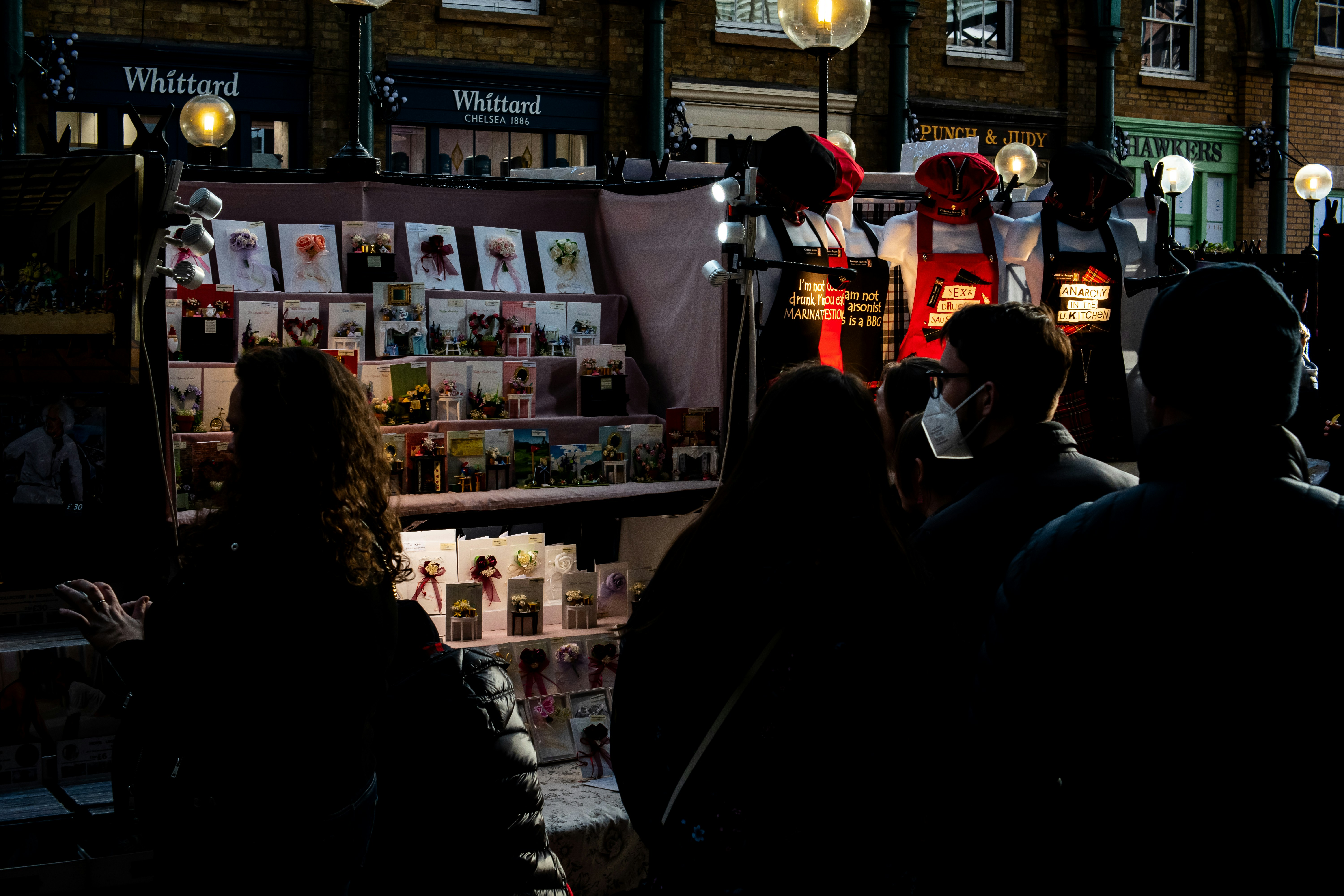Night Market Stall: Cards and Tourists Under Warm Neon