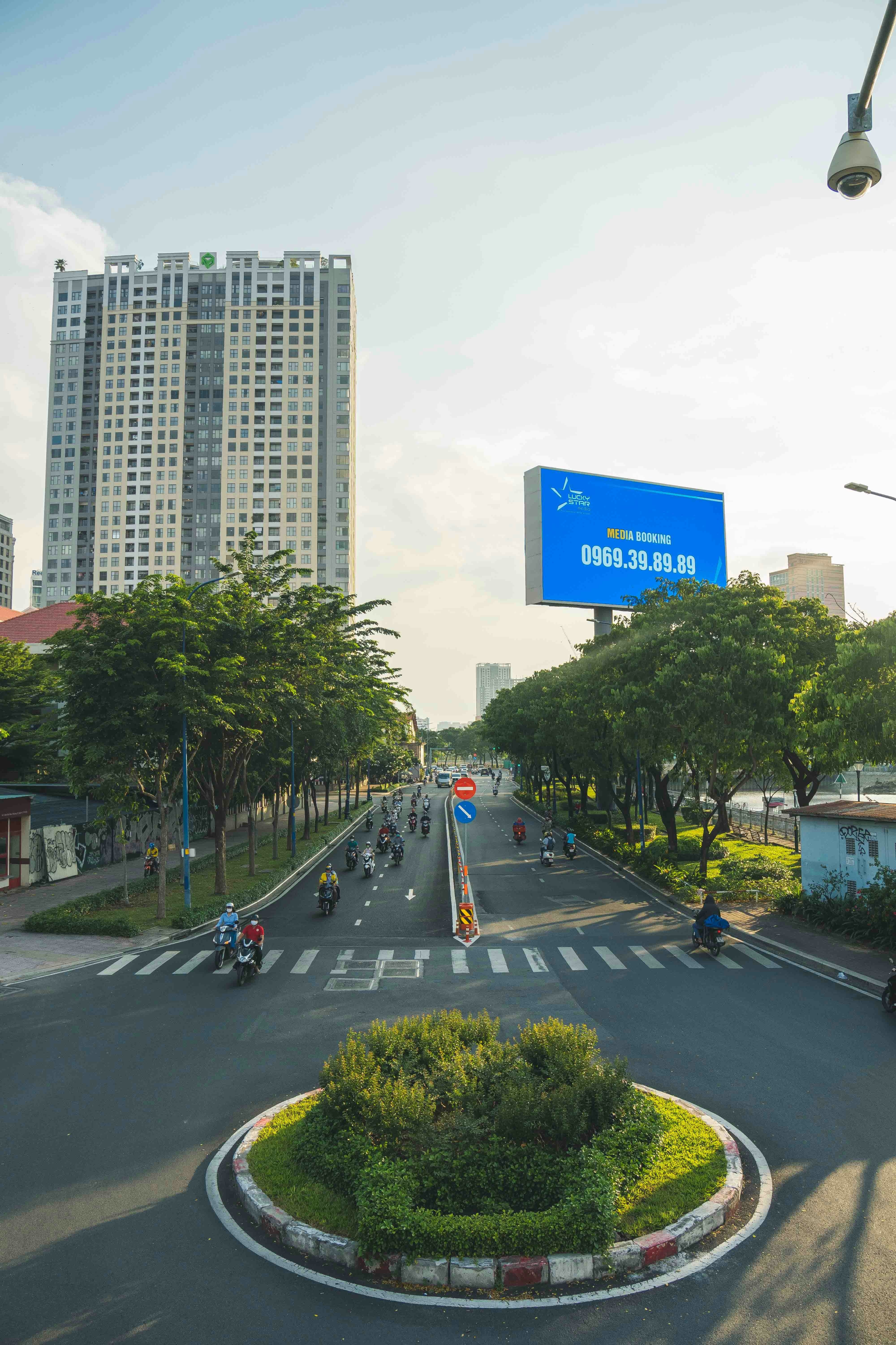A city street with a blue sign in the middle of it