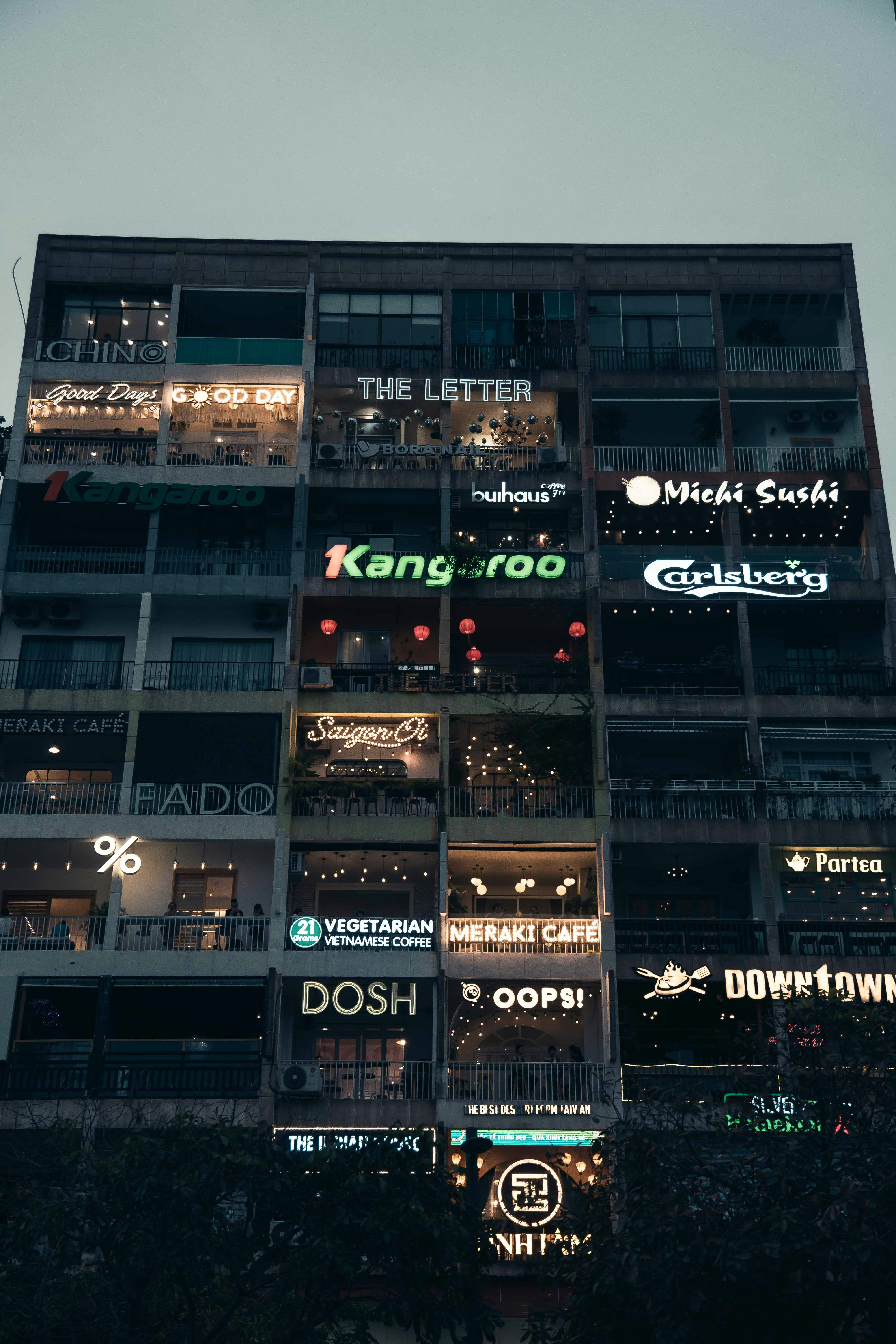 Kangaroo Neon: A Vertical Mosaic of Storefront Logos at Dusk