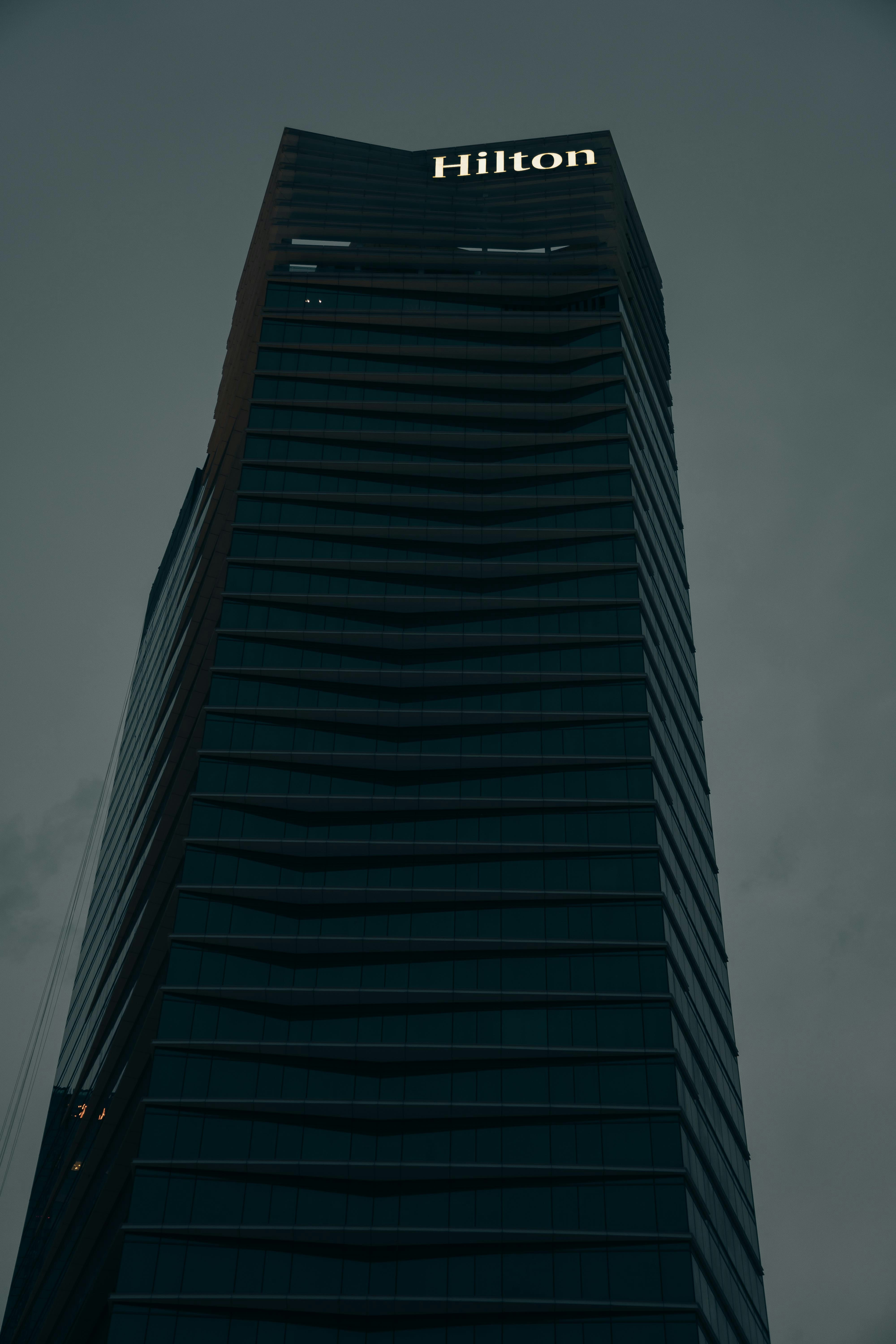 A tall building with a neon sign on the top of it