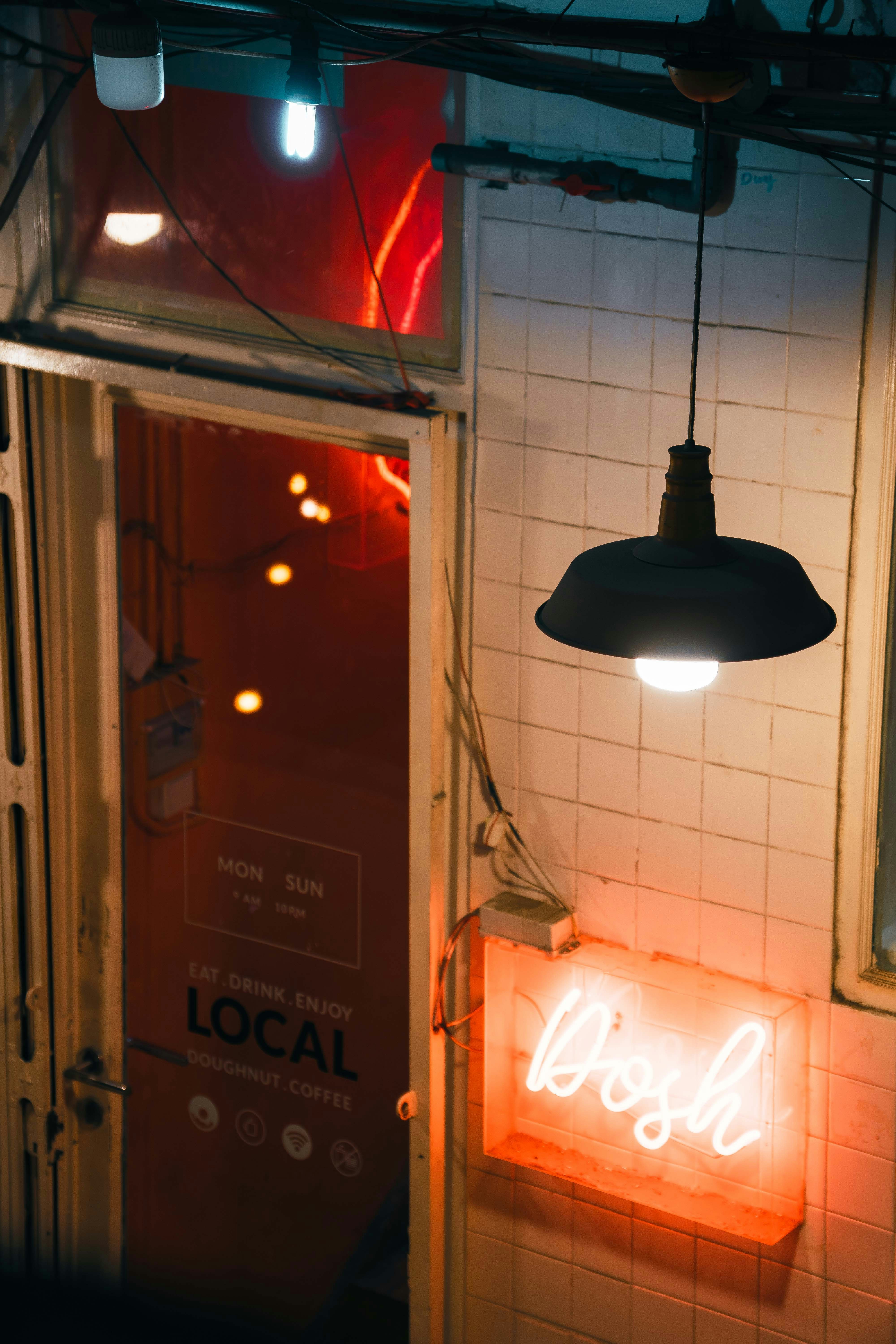 A neon sign hanging from the side of a building photo – Free Food Image ...