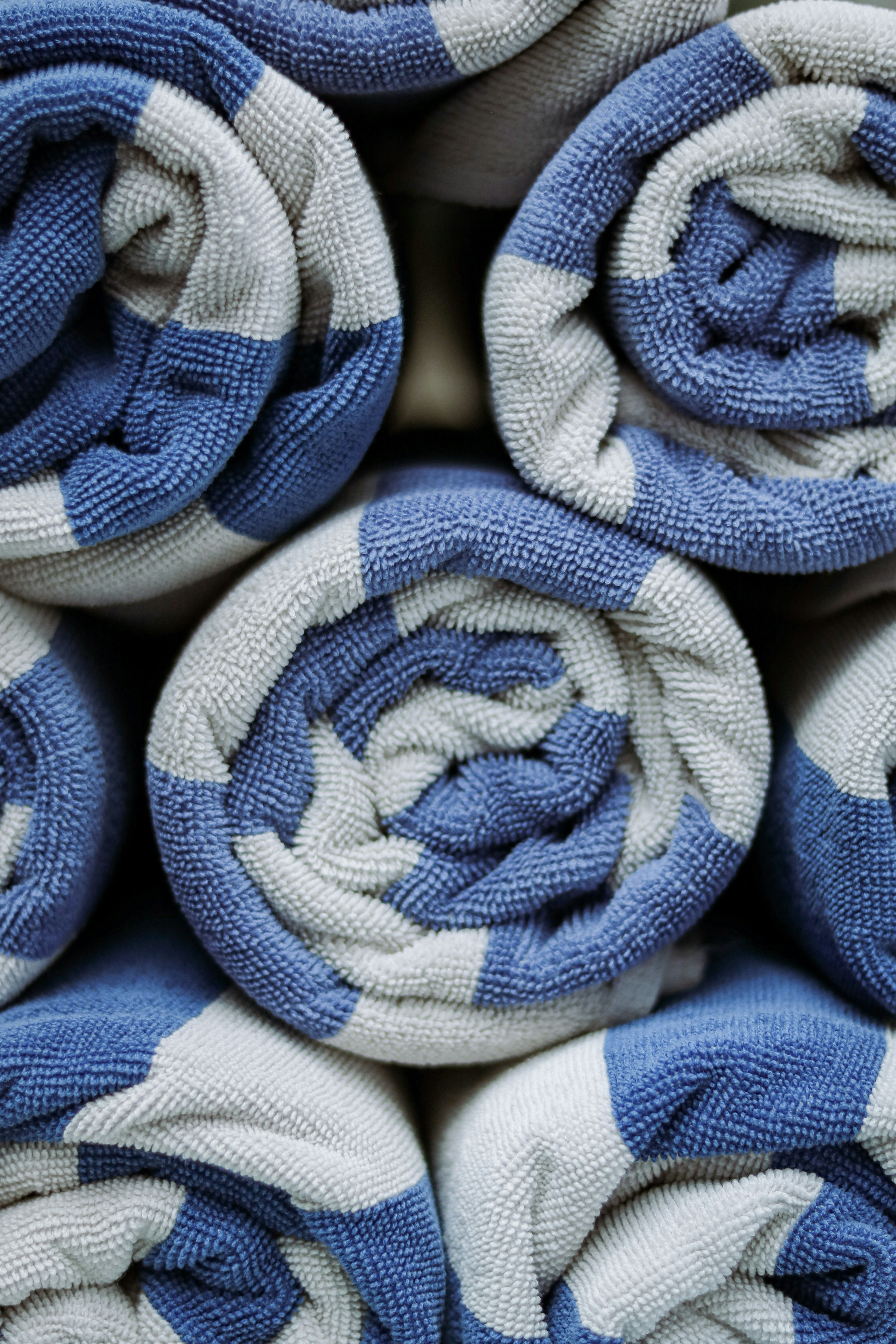 Neatly rolled blue and white towels stacked in a symmetrical pattern.