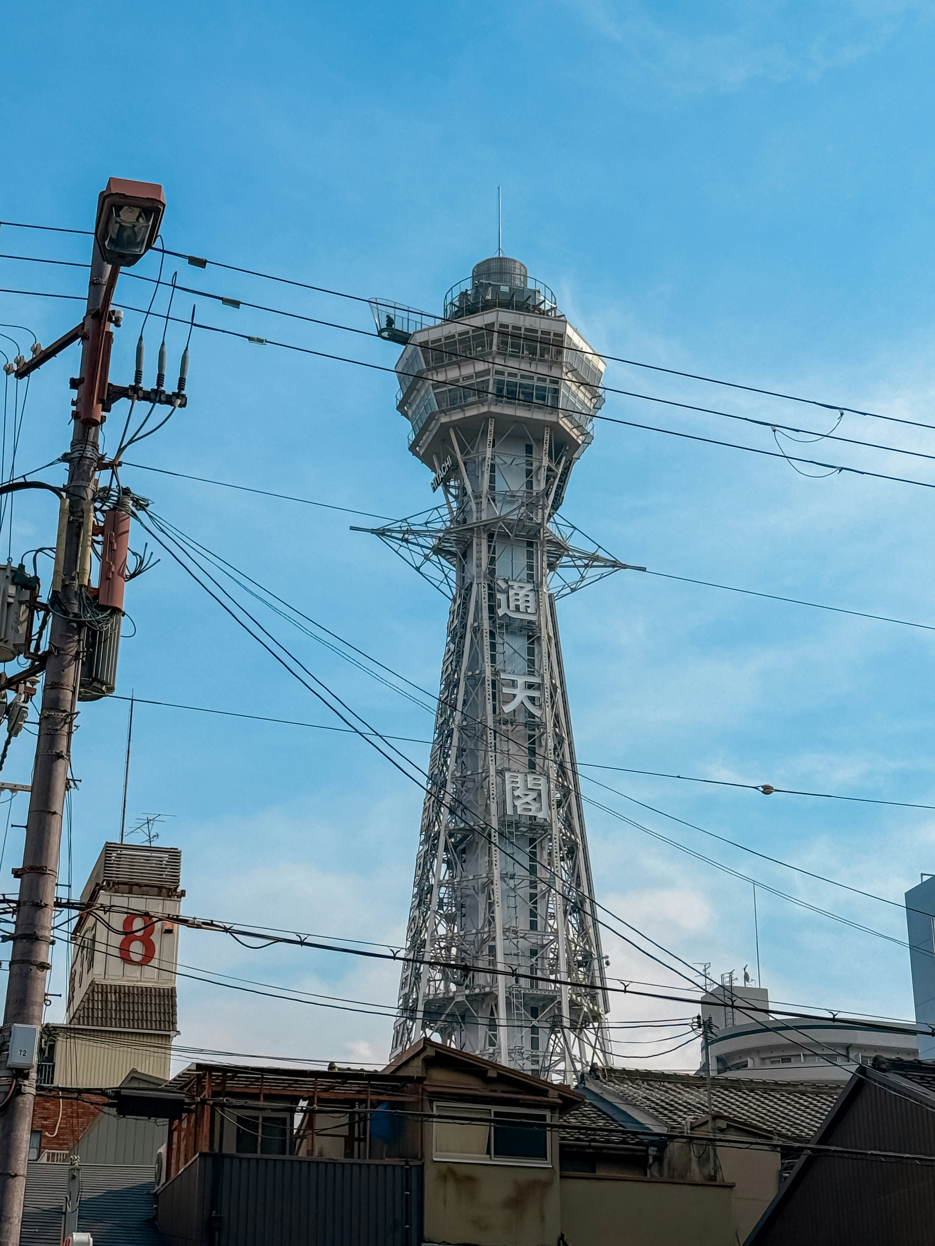 Tsutenkaku in a Lattice of Light: Tower Amid Cables Under a Bright Osaka Sky