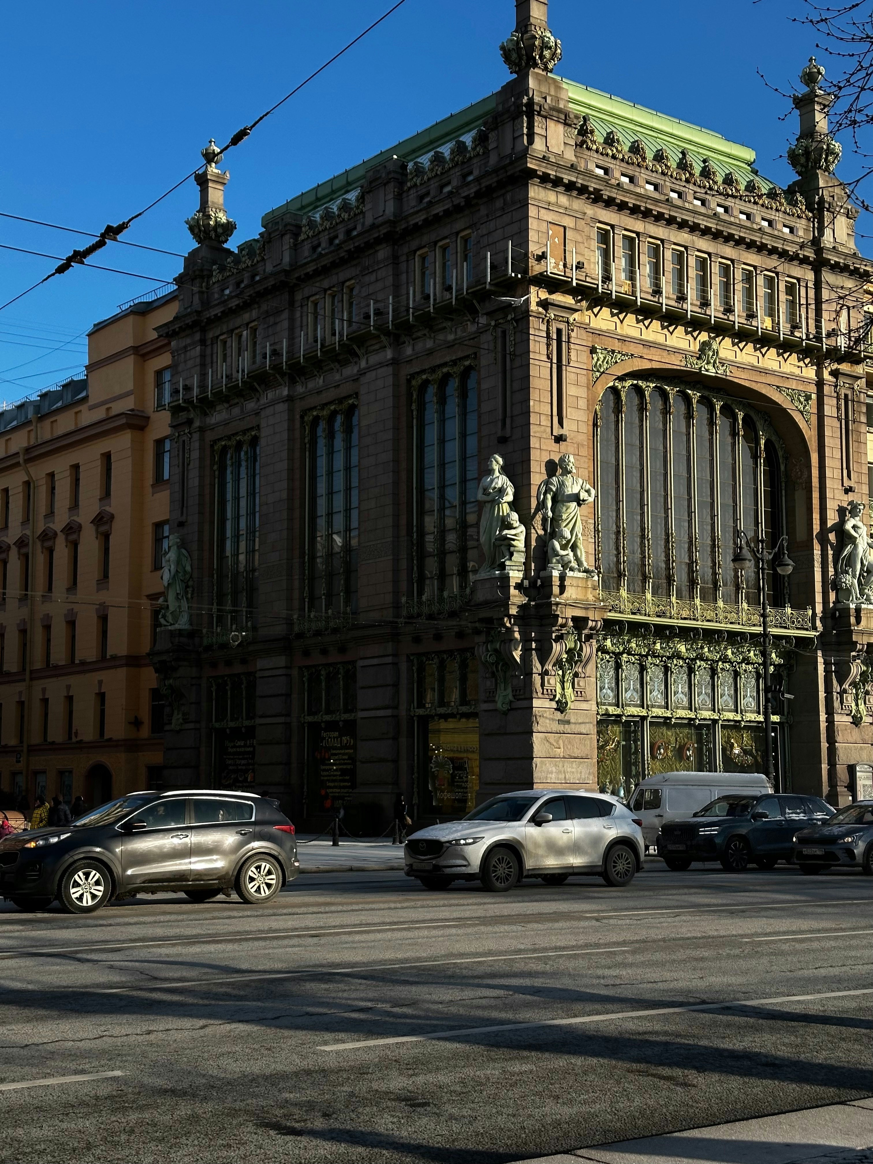 A large building with many cars parked in front of it photo – Free ...