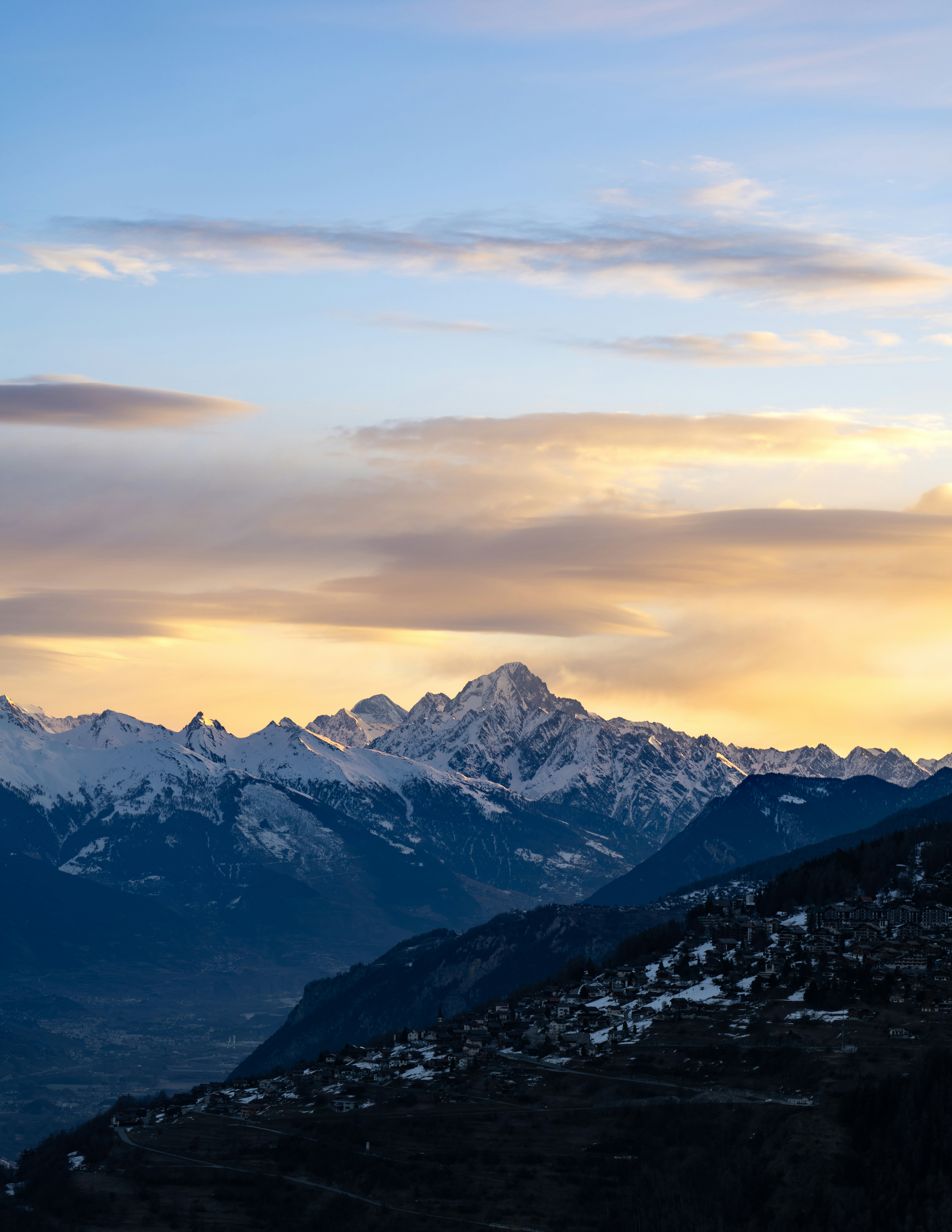 Twilight Over the Alpine Crown: Snow-Capped Peaks and a Quiet Valley